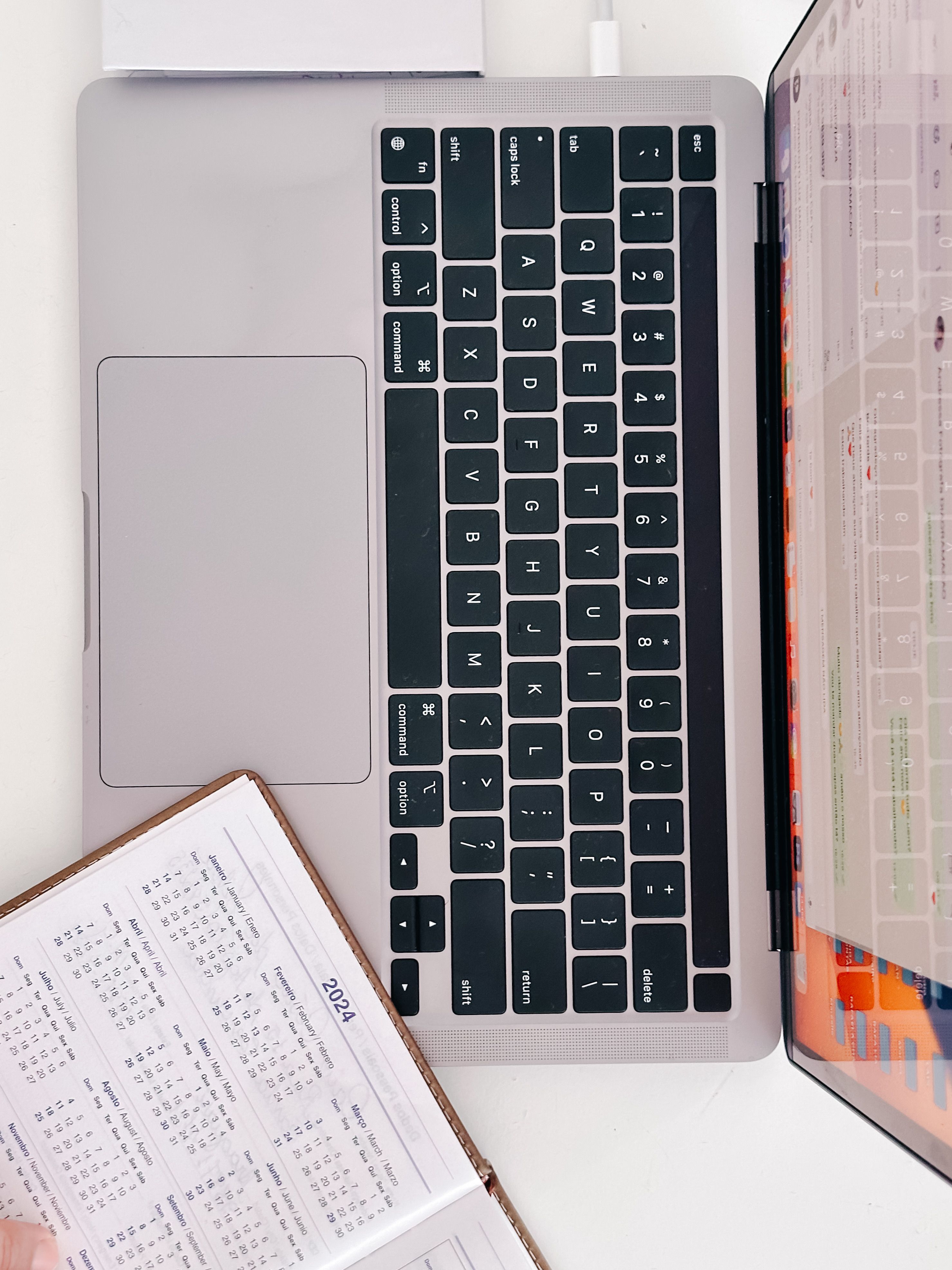 A person is using a laptop and a notebook · Free Stock Photo