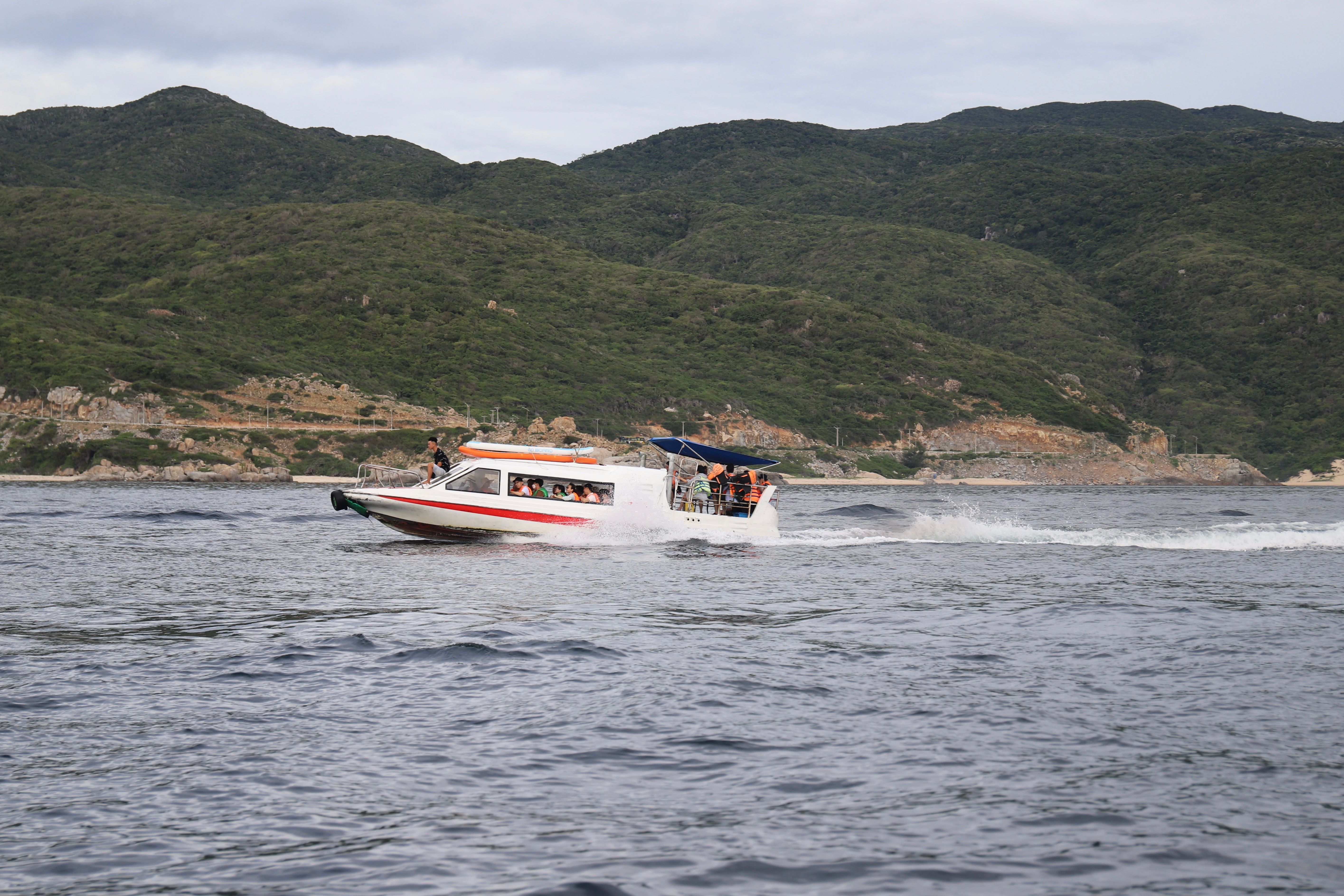 A boat traveling on the water near mountains · Free Stock Photo