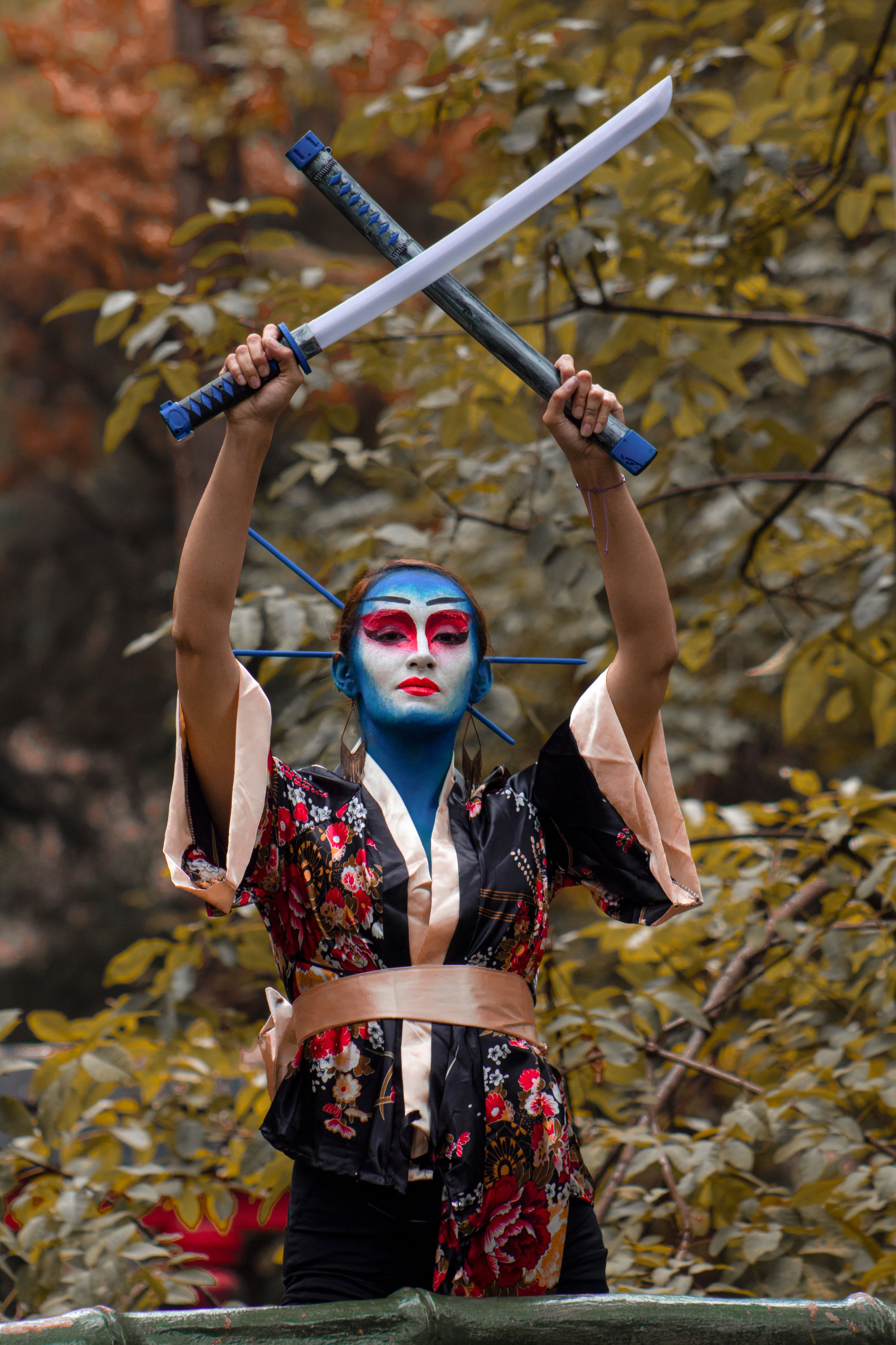 A woman in a blue mask holding two swords · Free Stock Photo