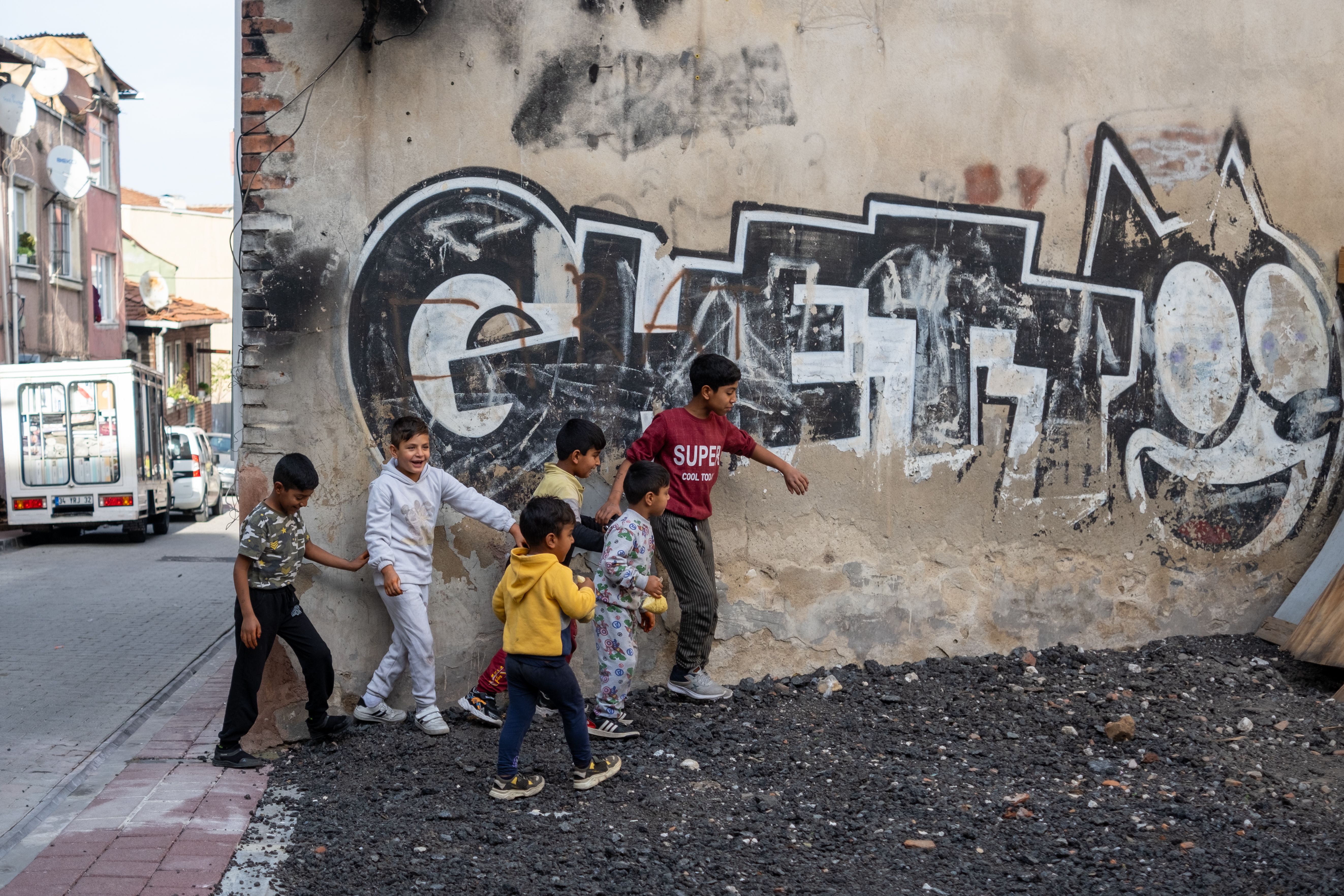 A group of children playing in front of a wall with graffiti · Free ...