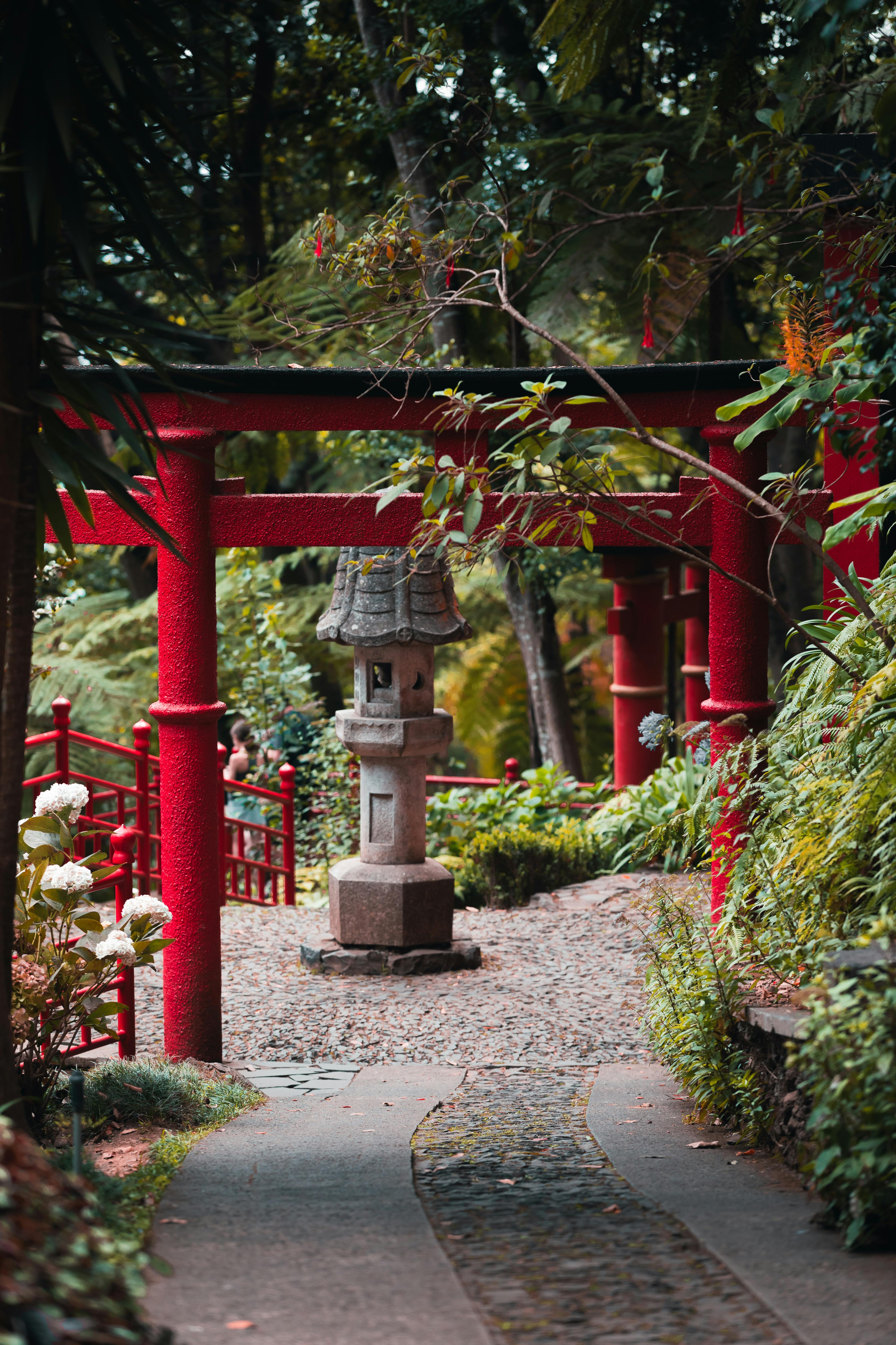 A red tori gate in a garden · Free Stock Photo