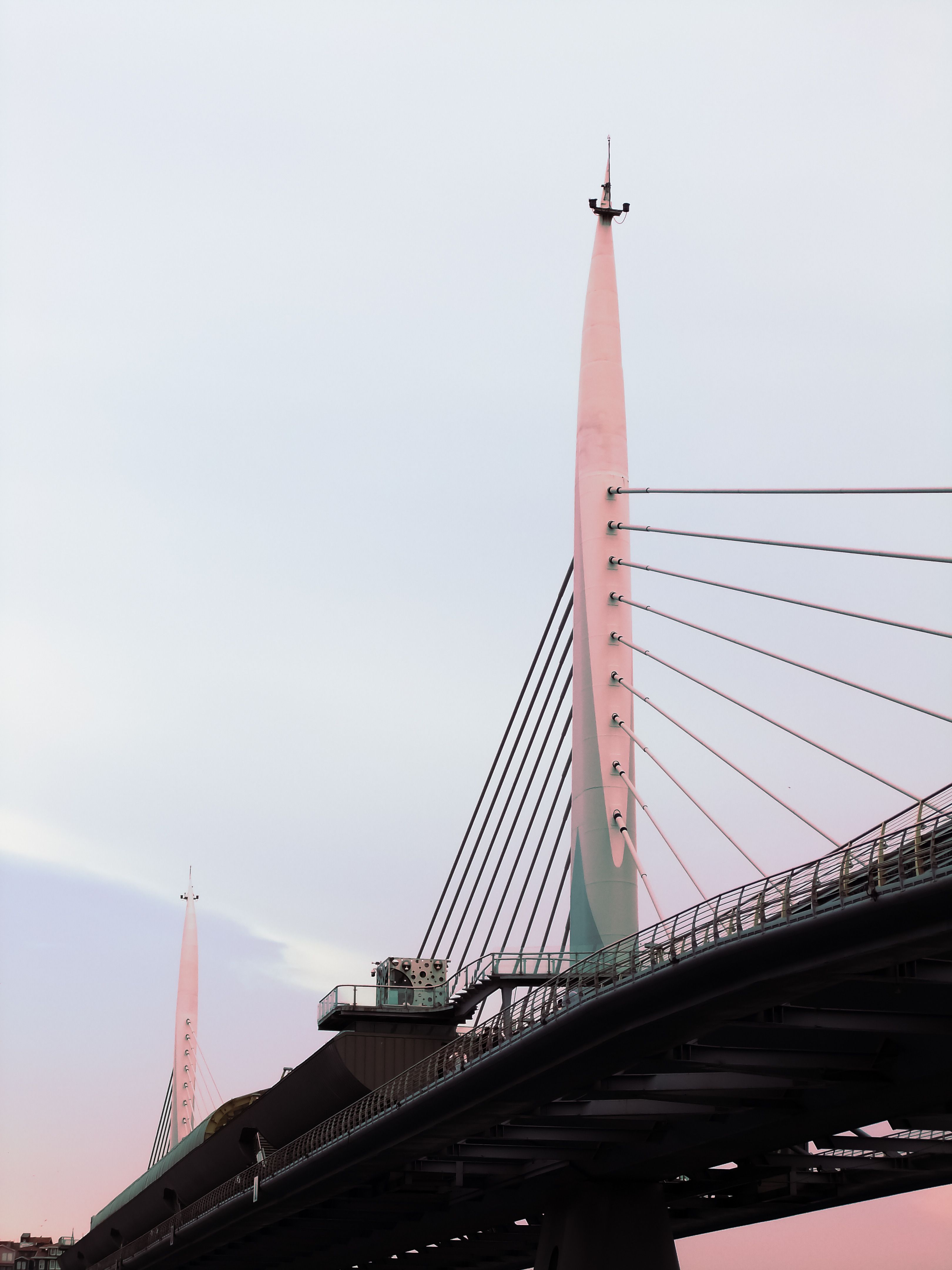 A bridge with a tall tower and a pink sky · Free Stock Photo