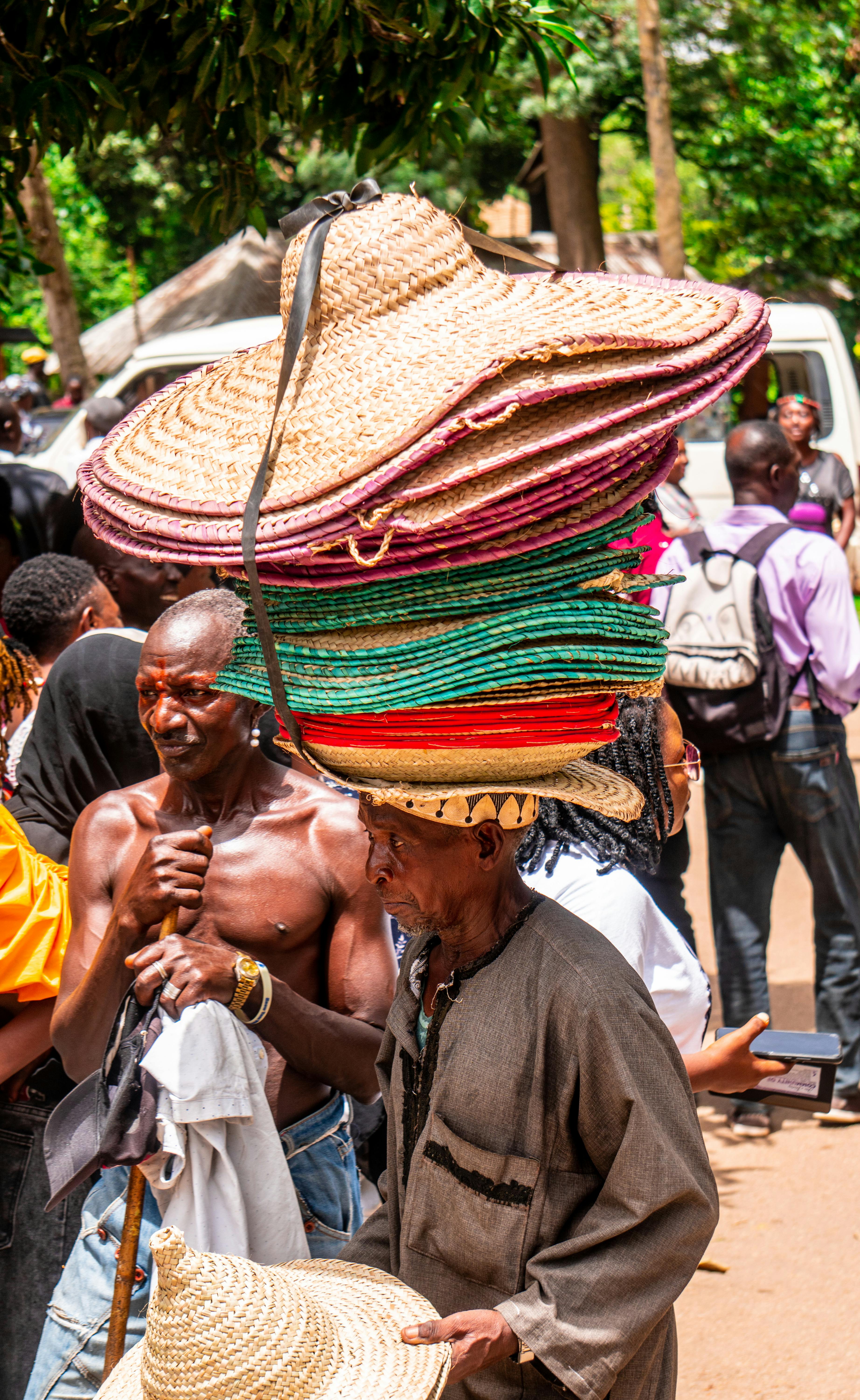 A man carrying a stack of hats on his head · Free Stock Photo