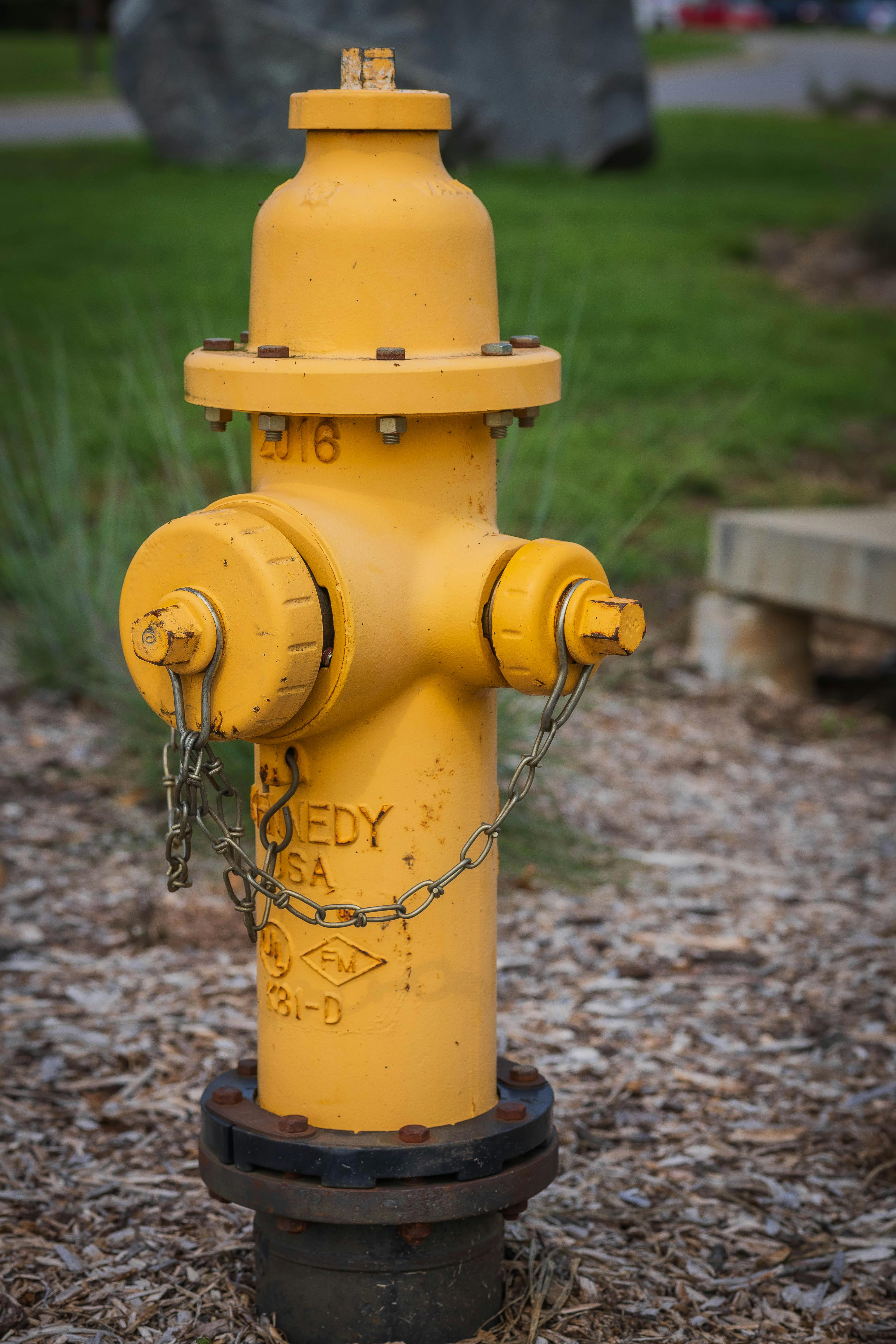 A yellow fire hydrant with a chain around it · Free Stock Photo