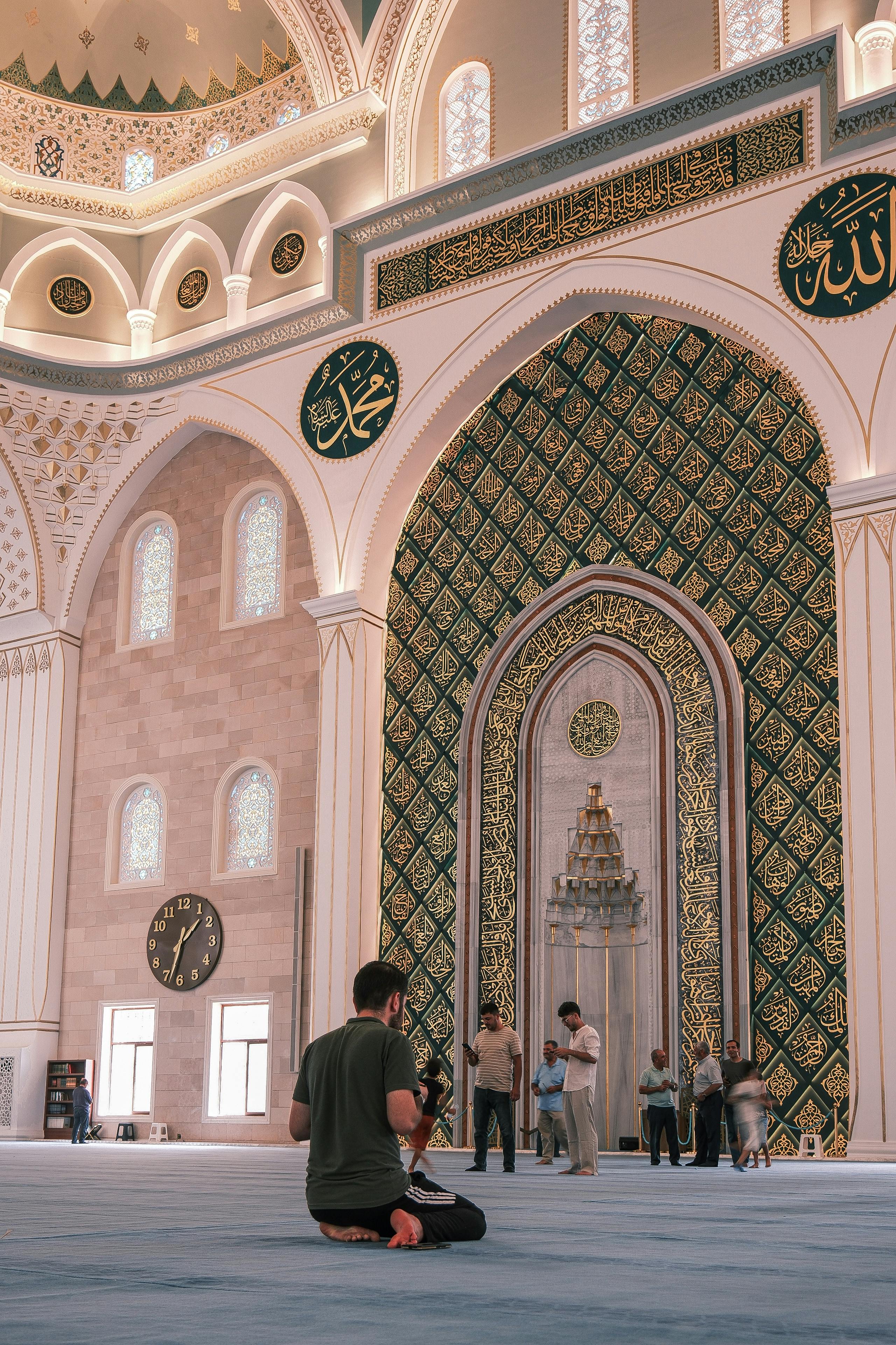 A man sitting on the floor in front of a mosque · Free Stock Photo