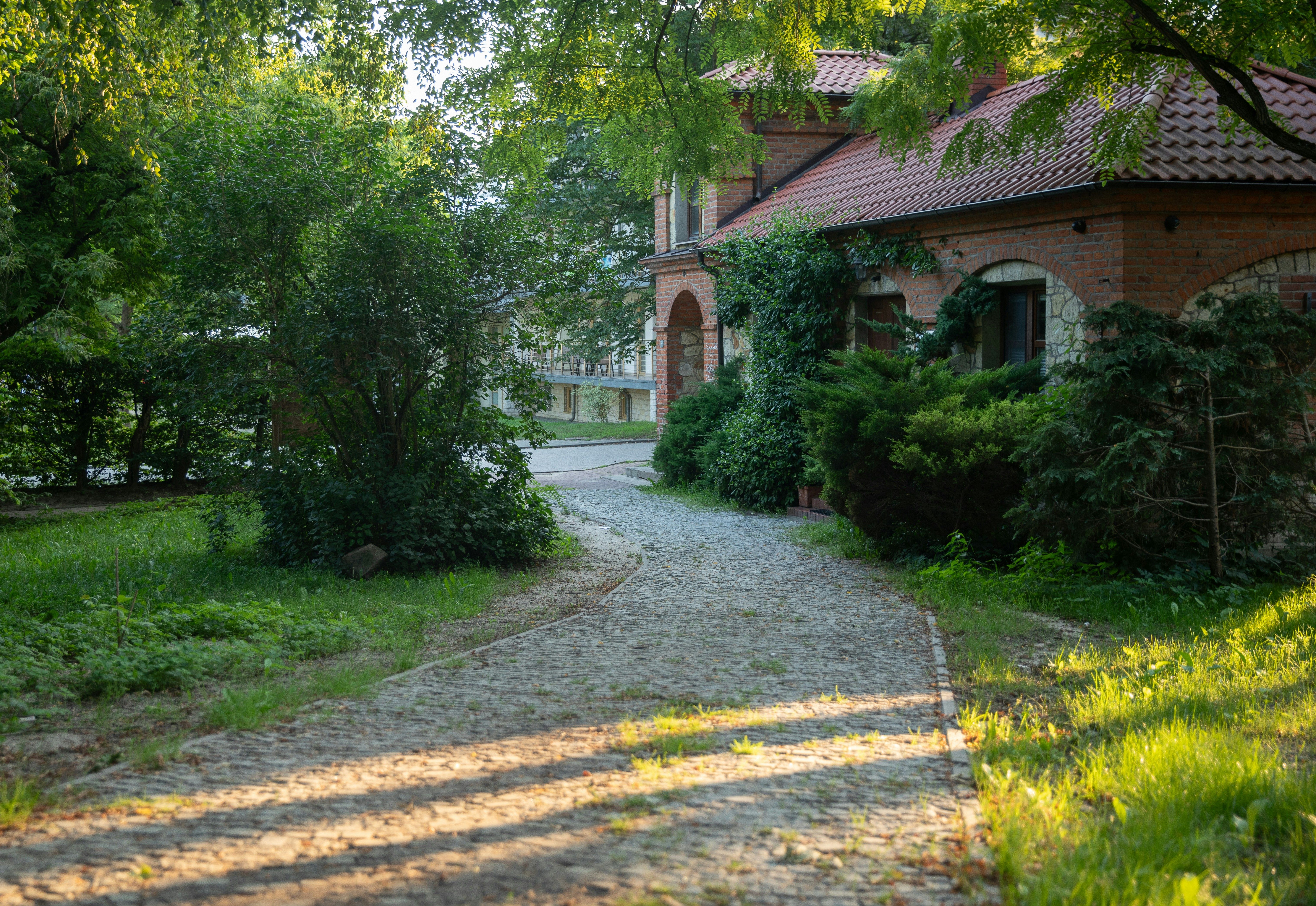 A path leading to a house with trees and grass · Free Stock Photo