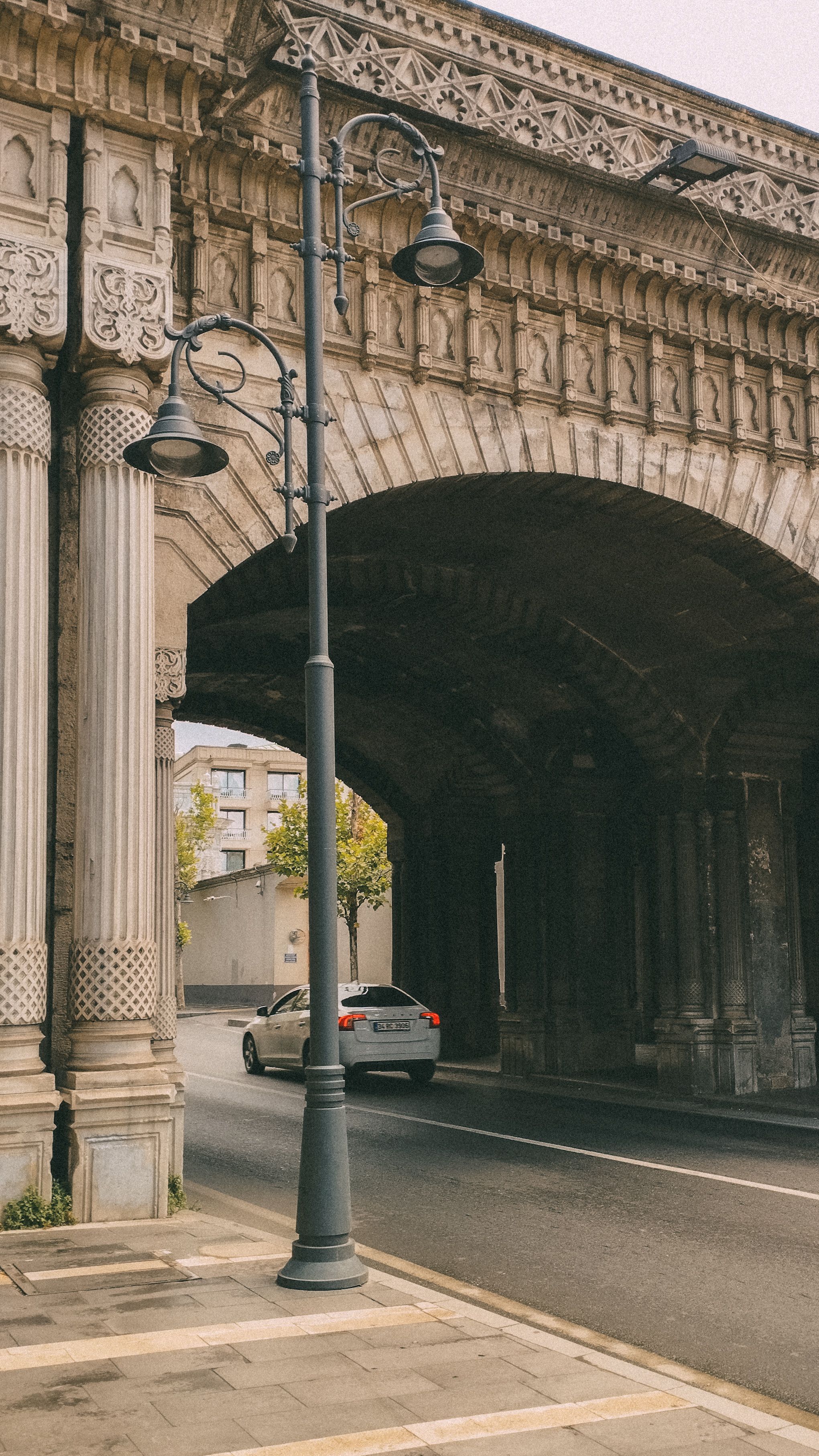 A car driving under a bridge with a street light · Free Stock Photo