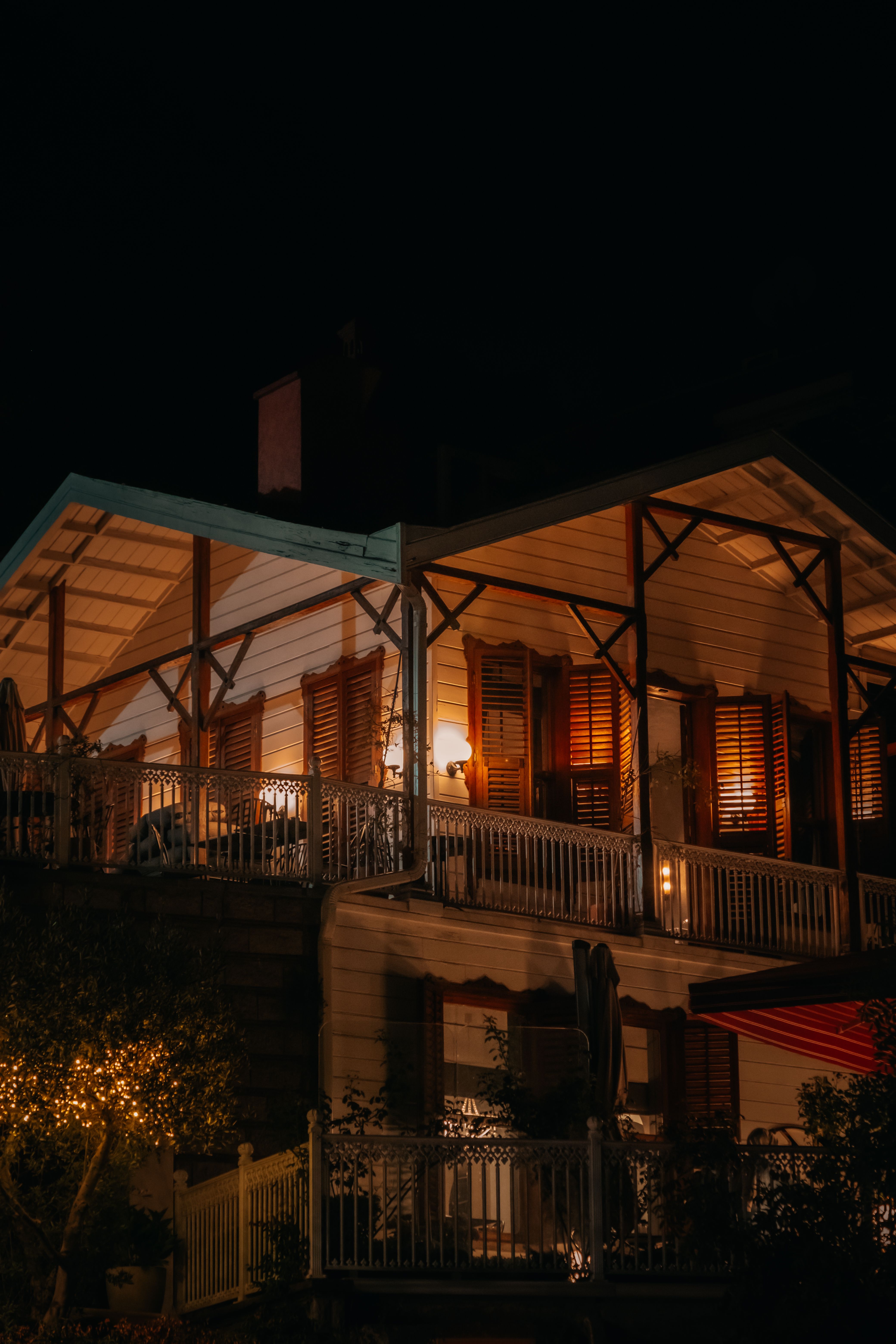 A house lit up at night with a porch and lights · Free Stock Photo