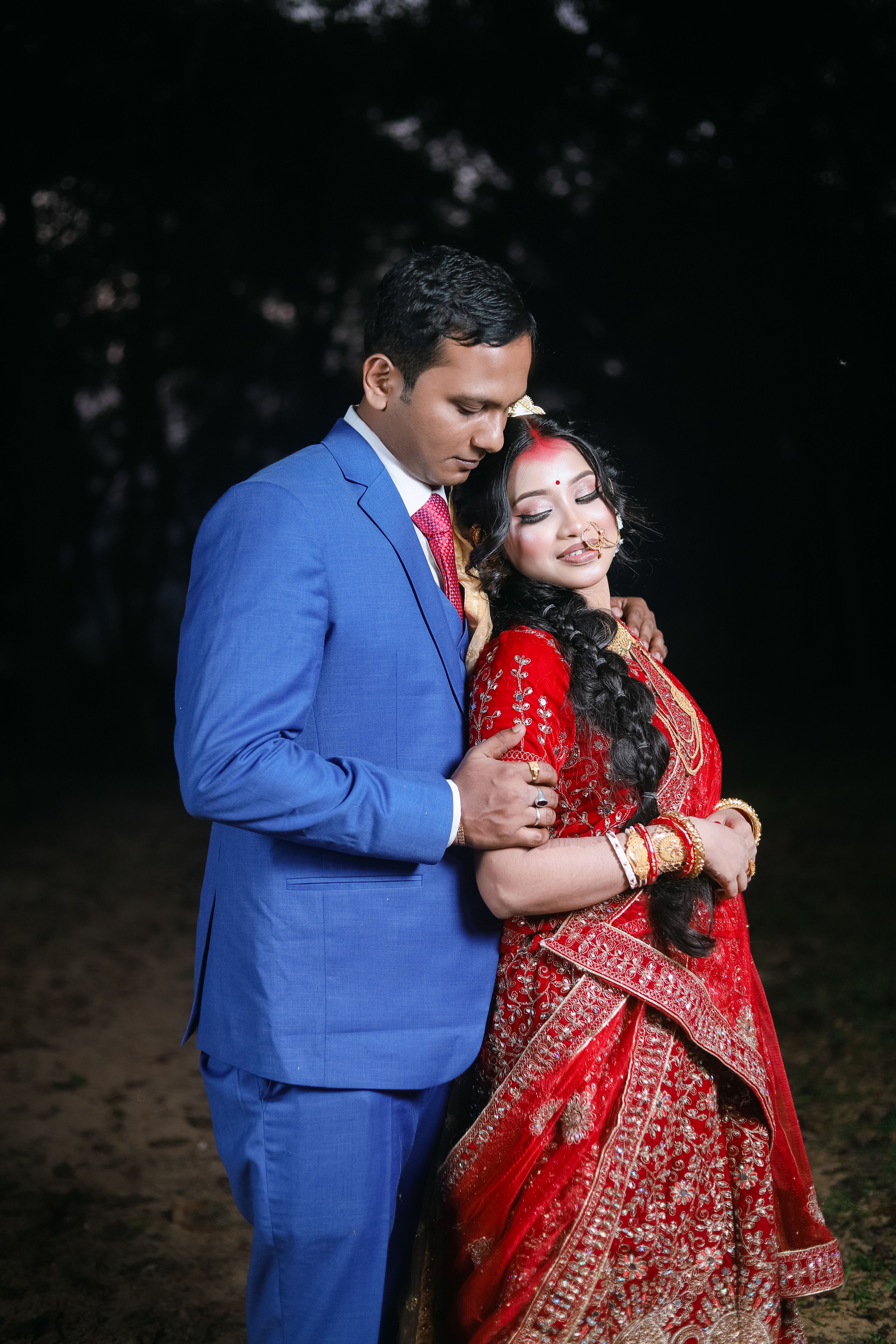 A couple in traditional attire pose for a photo in the woods · Free ...