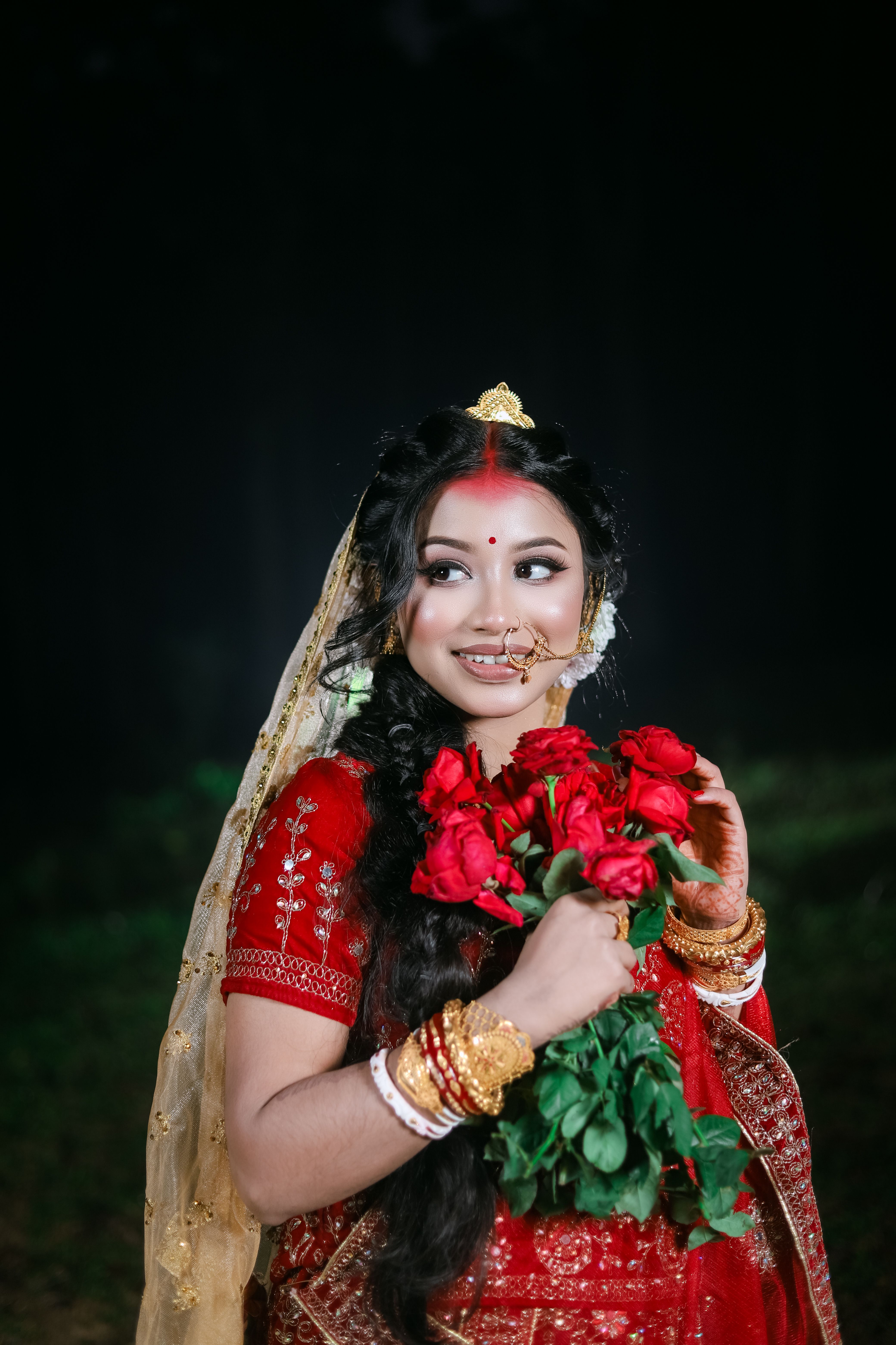 A beautiful indian bride in traditional attire holding red roses · Free ...