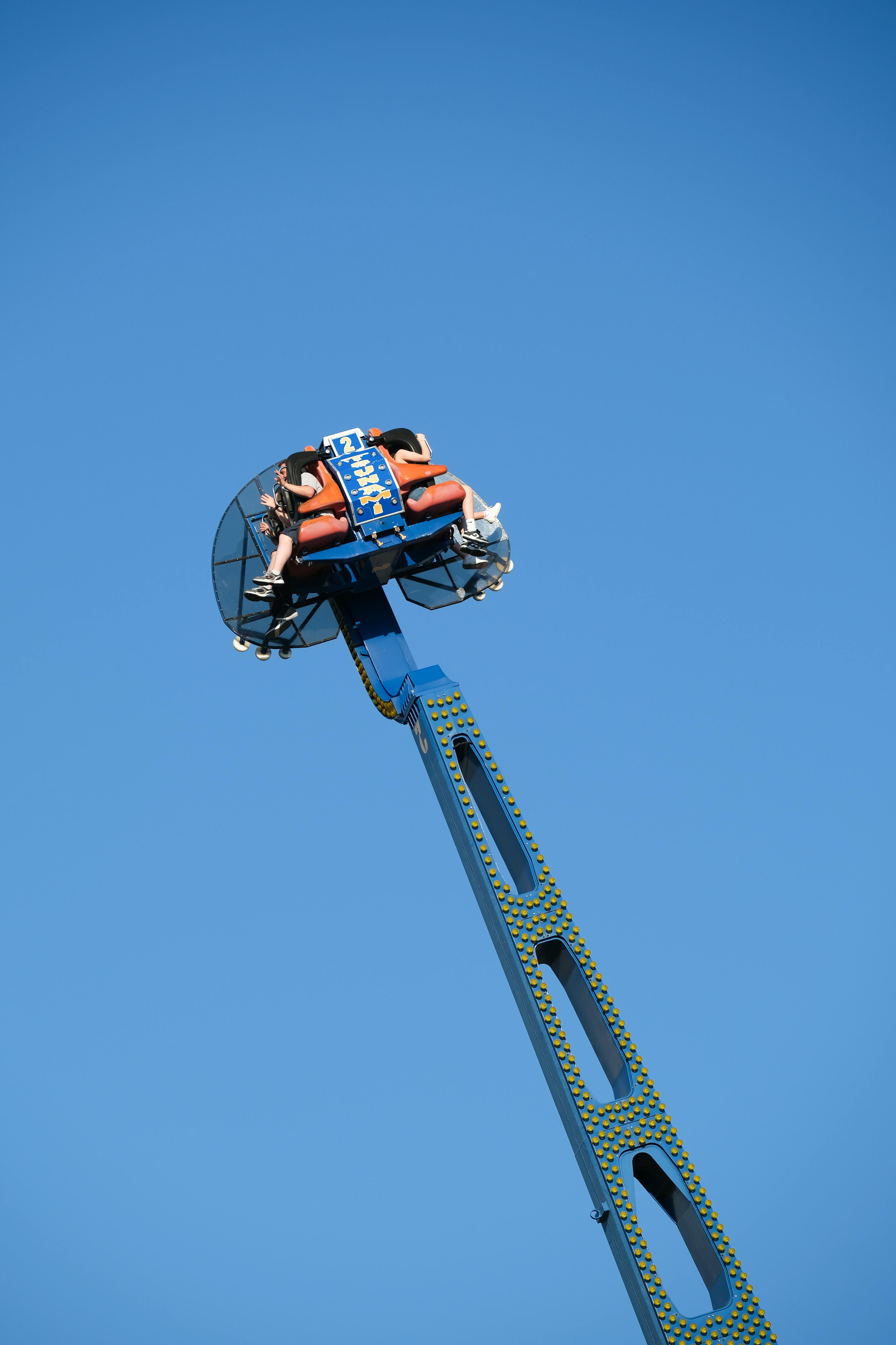 High Thrill Ride Soaring Against Clear Blue Sky · Free Stock Photo