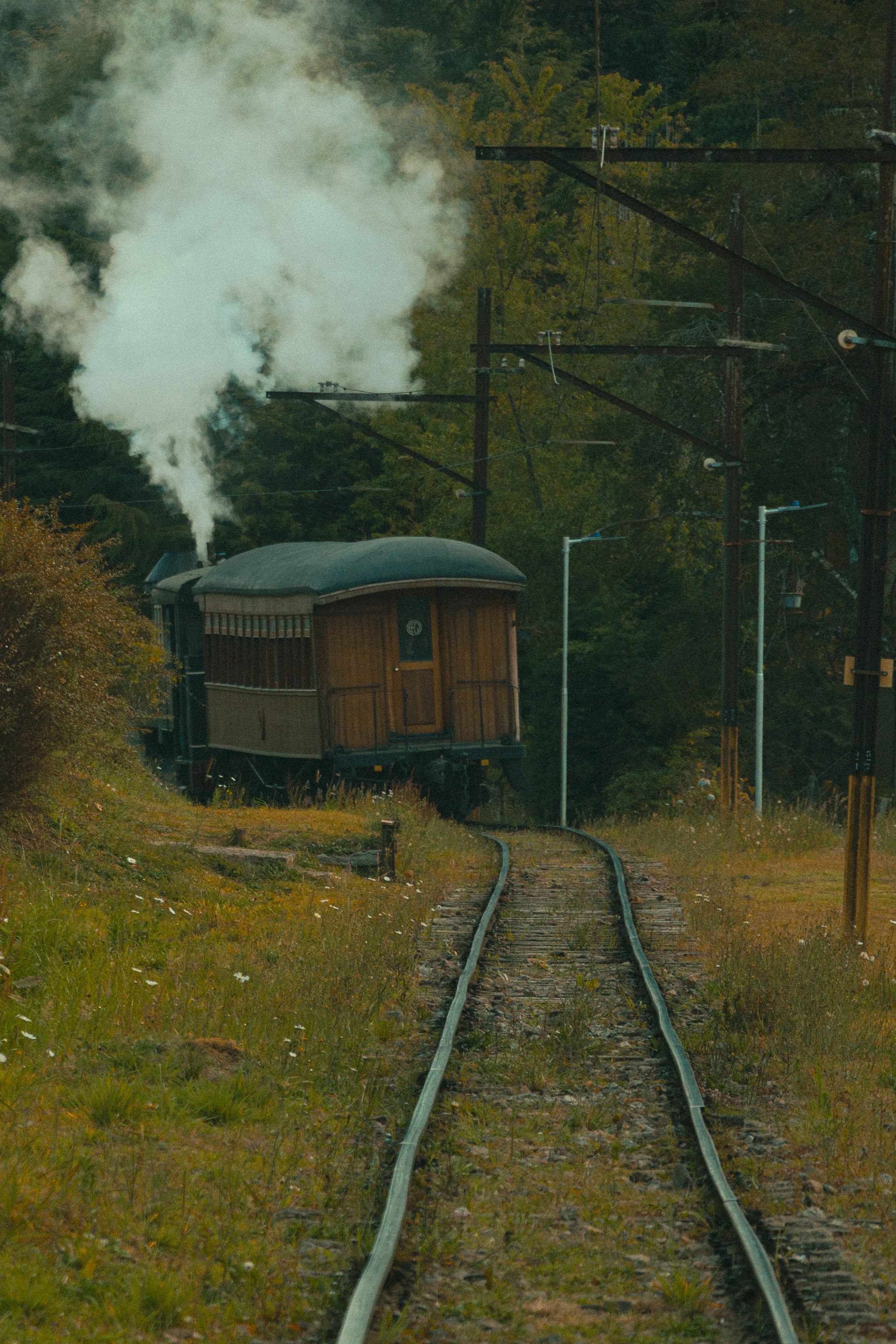 A train is traveling down the tracks with smoke coming out of the ...