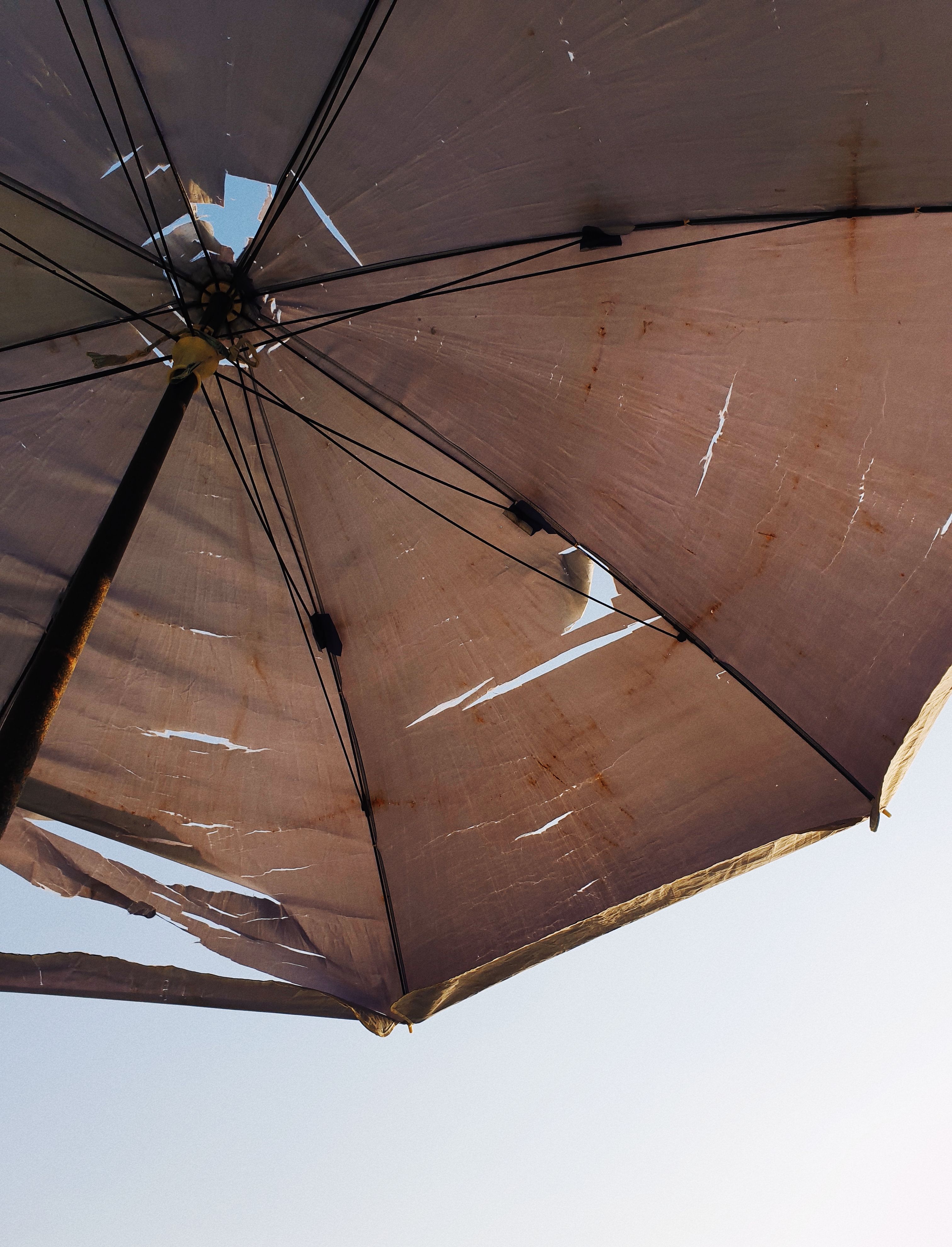 A close up of an open umbrella with a hole in it · Free Stock Photo