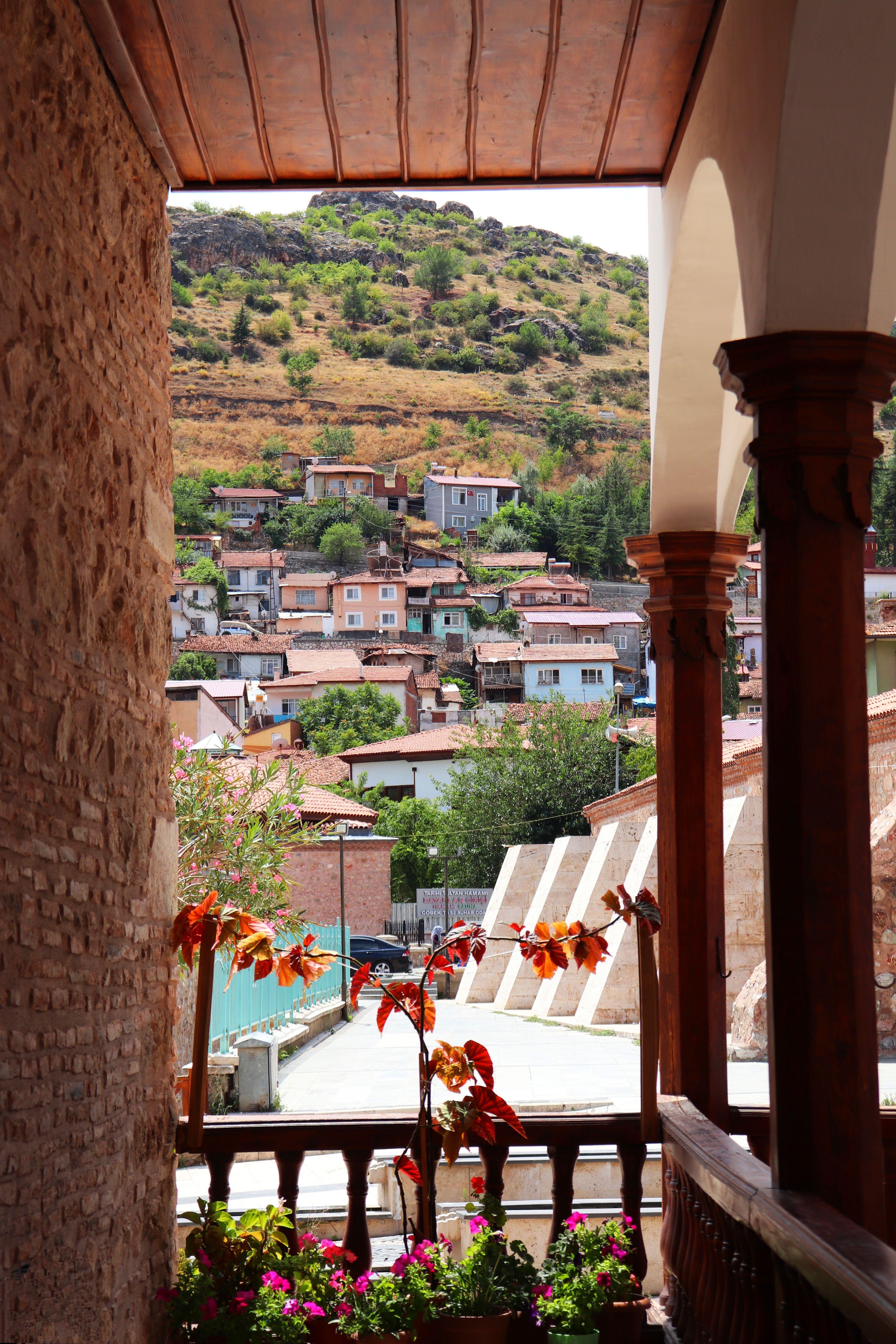 A balcony with a view of a town and flowers · Free Stock Photo