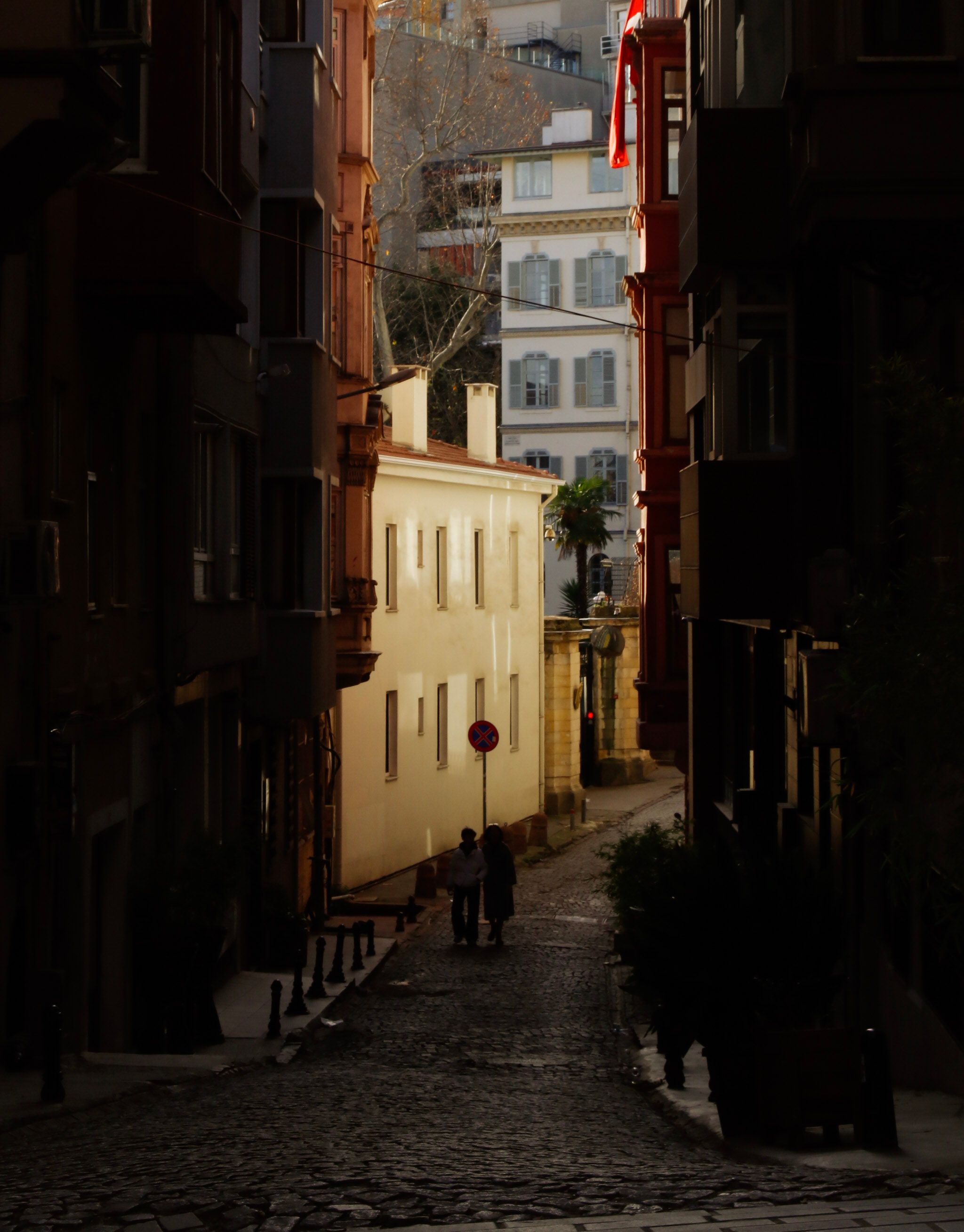 A person is walking down a narrow street · Free Stock Photo