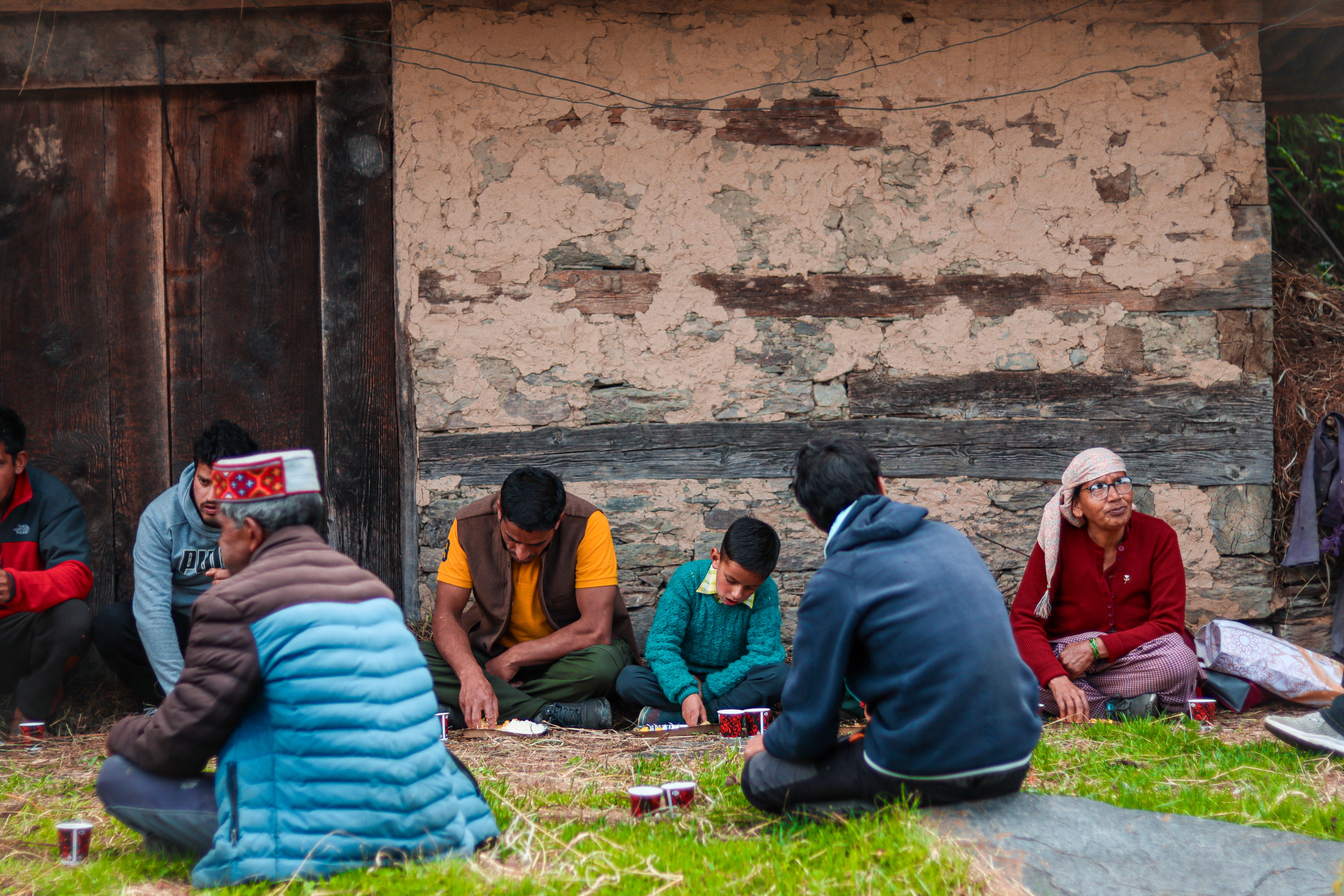 A group of people sitting on the ground outside · Free Stock Photo