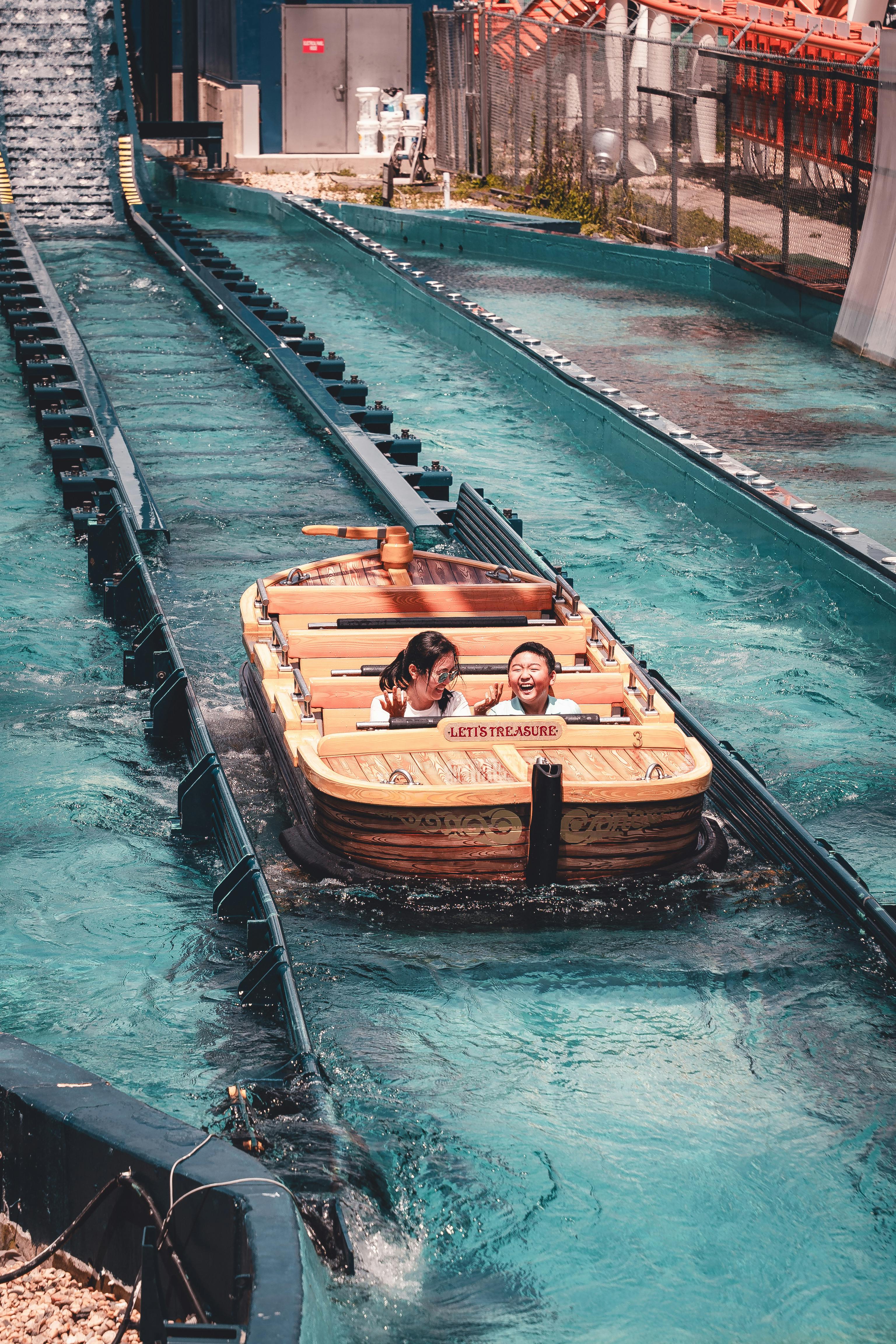 A wooden boat is being pulled by a water slide · Free Stock Photo