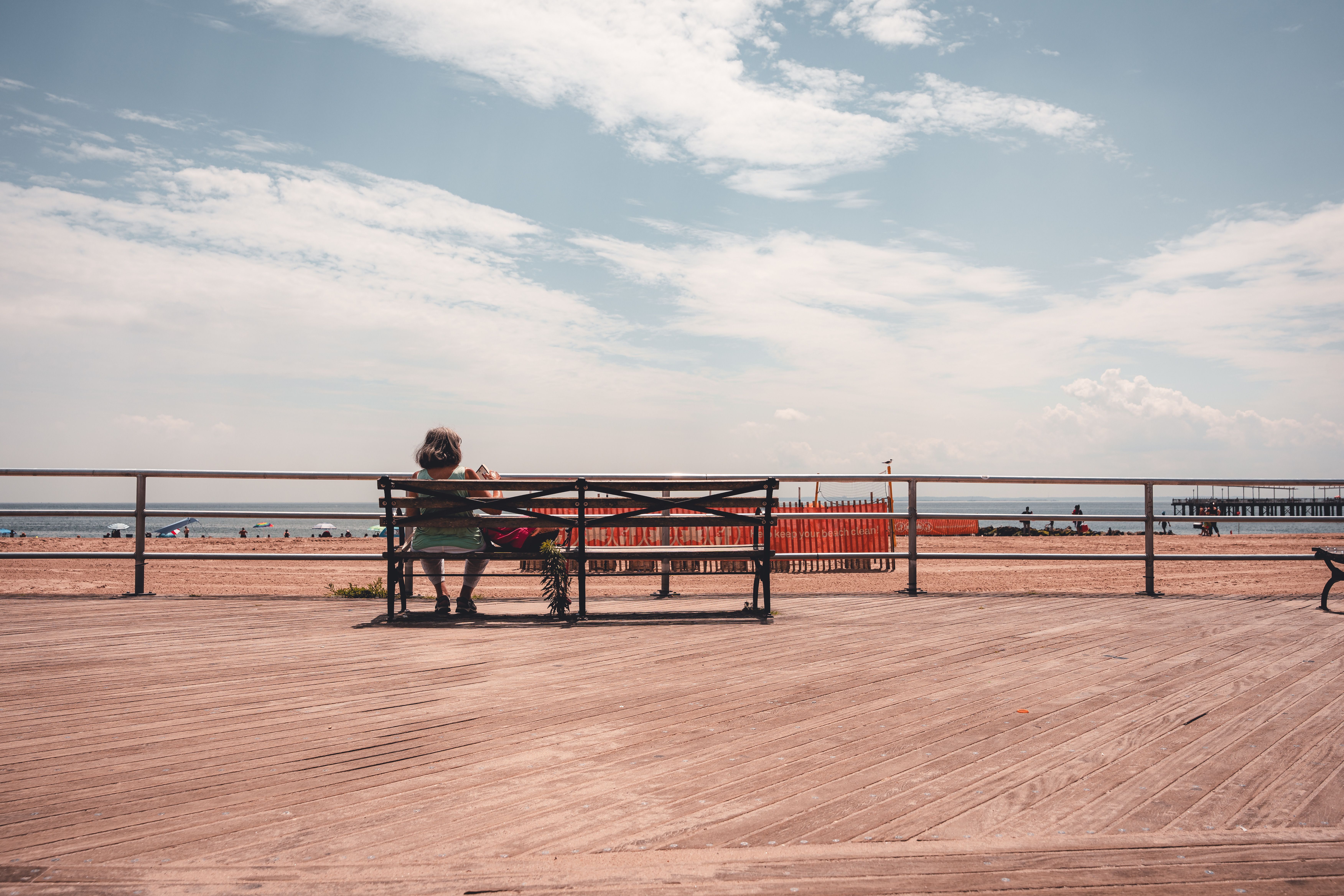 A person sitting on a bench on a pier · Free Stock Photo