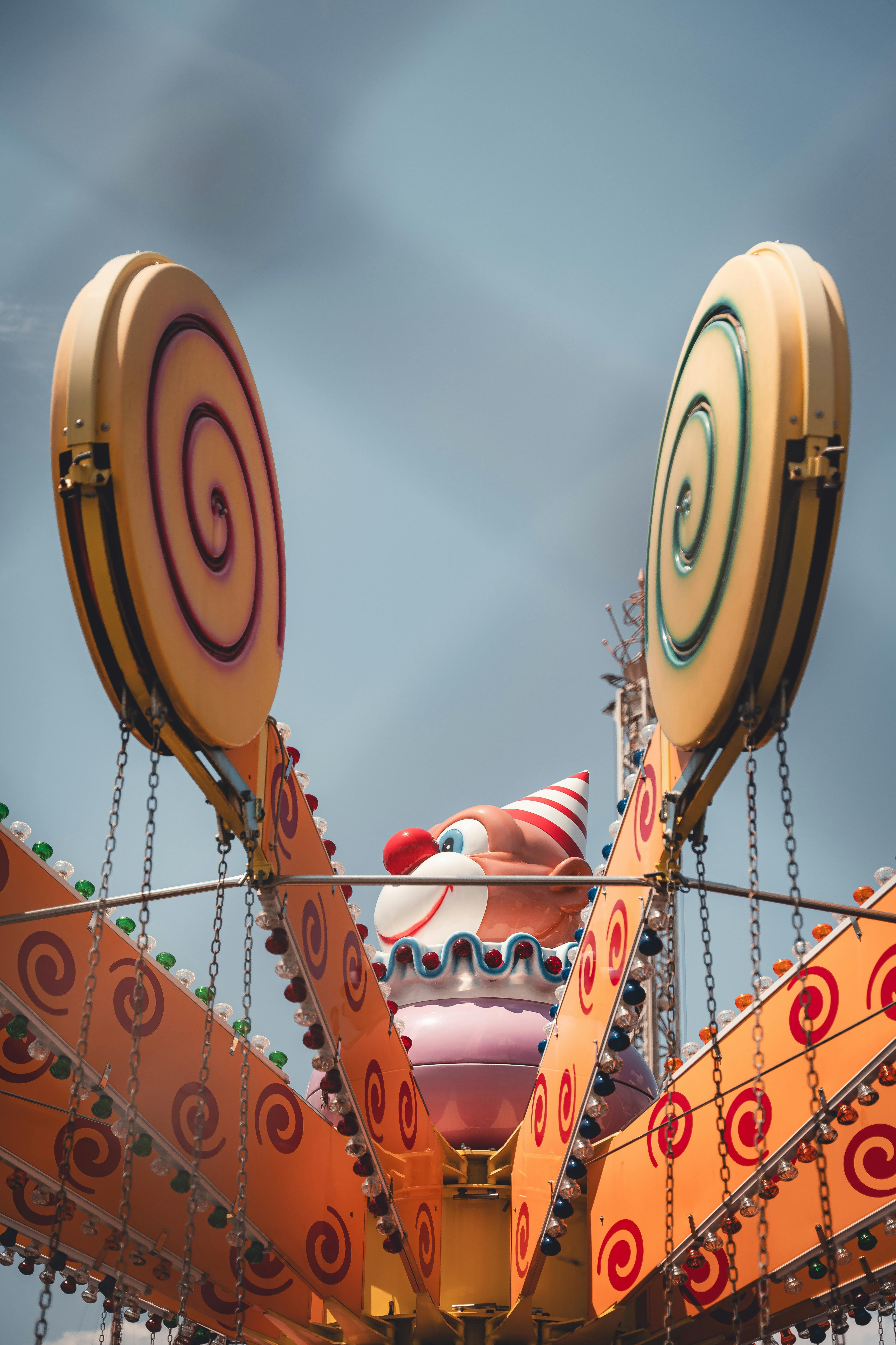 A carnival ride with colorful wheels and a clown · Free Stock Photo