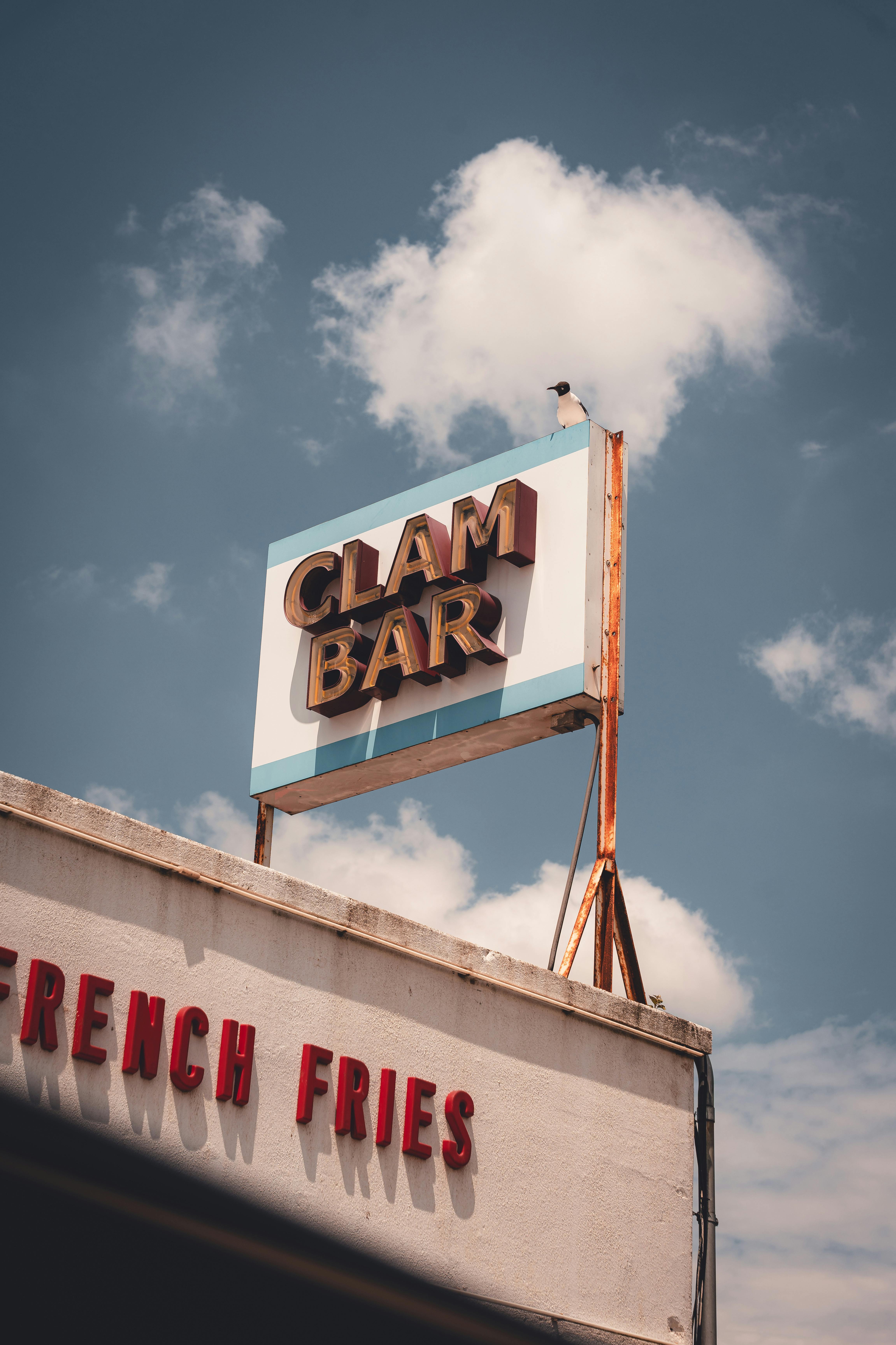 A sign for clam bar on a building · Free Stock Photo