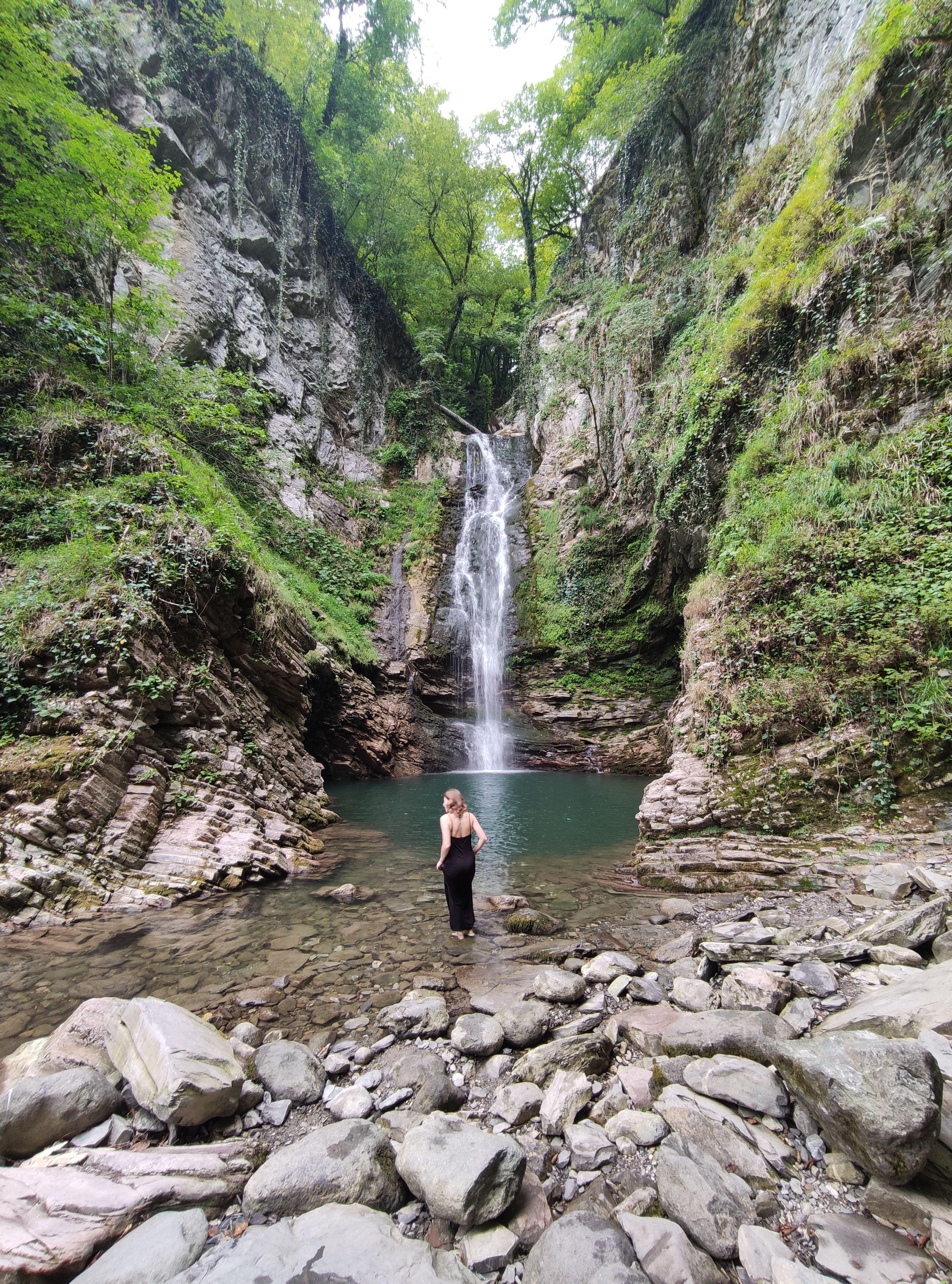 A person standing in front of a waterfall · Free Stock Photo