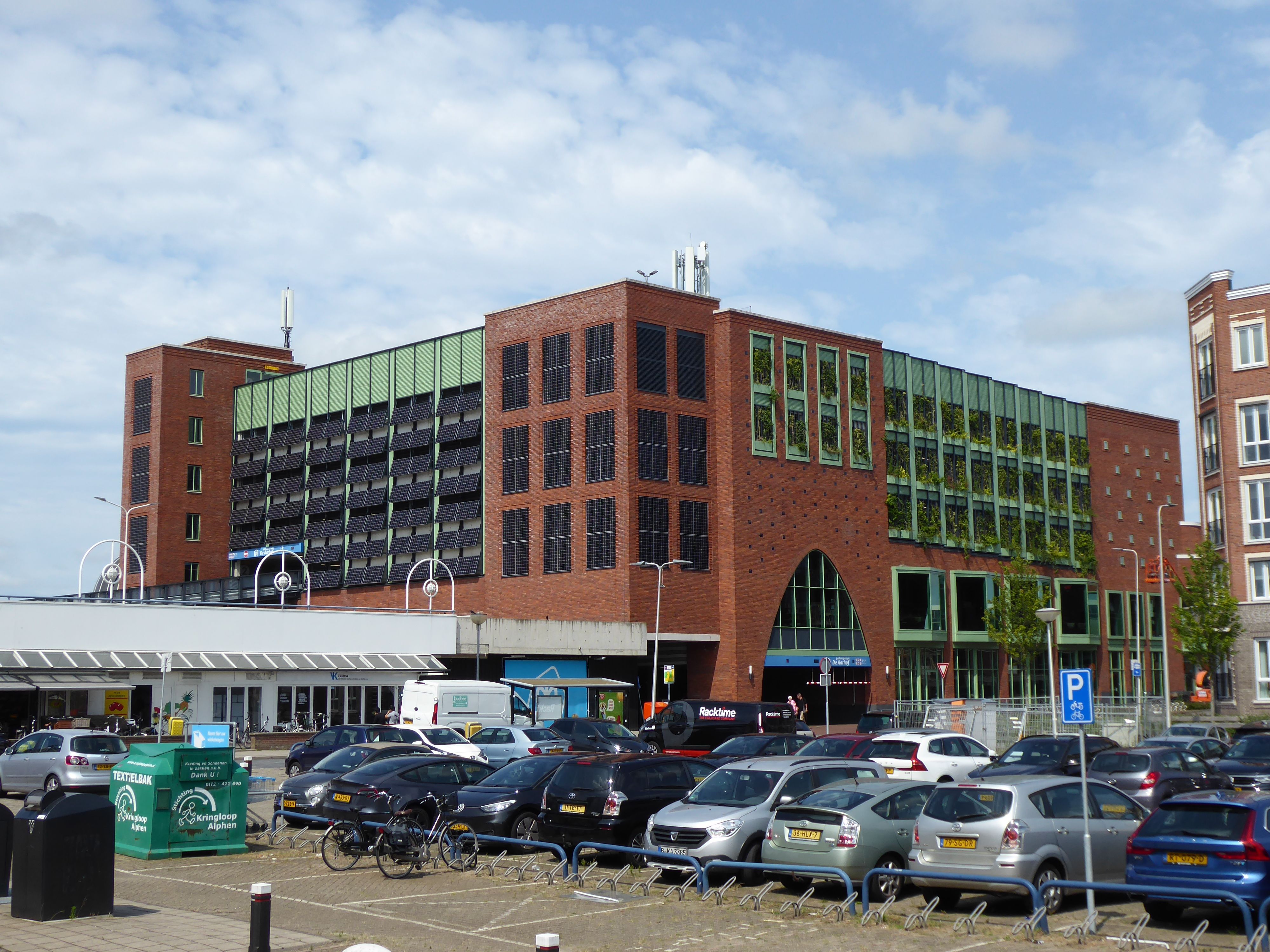 A large building with cars parked in front of it · Free Stock Photo