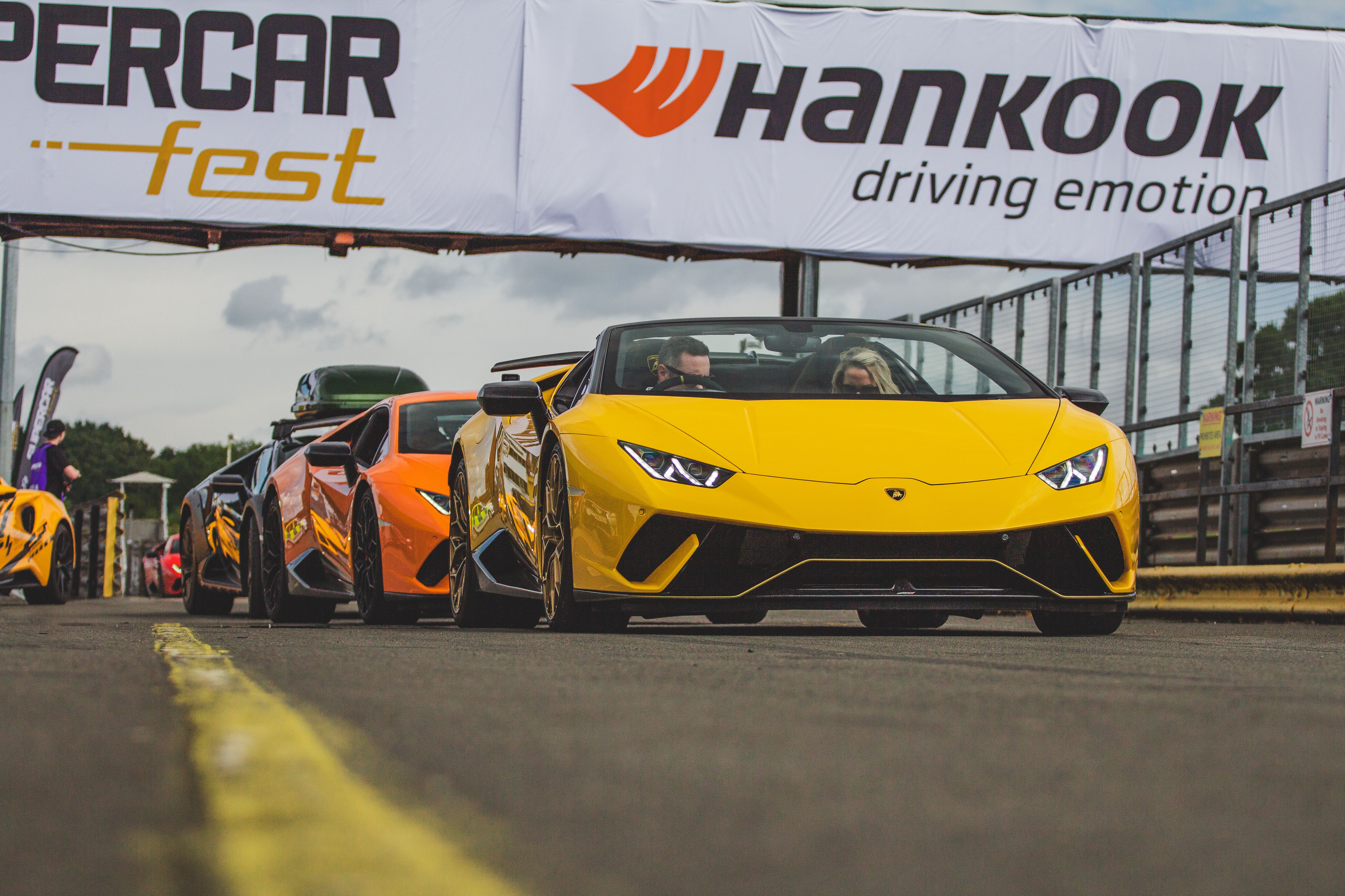 A group of cars driving on a track · Free Stock Photo