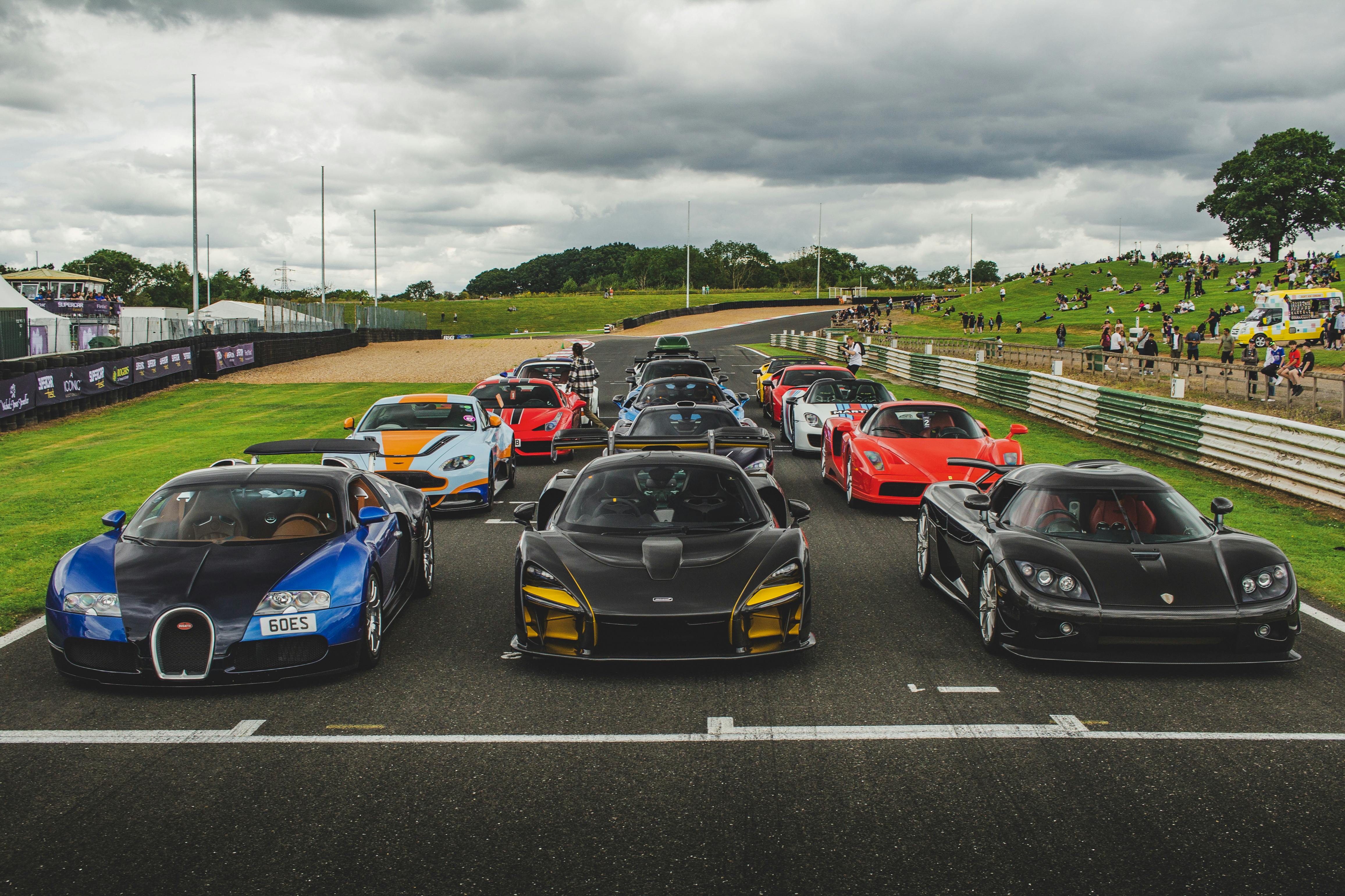 A group of supercars lined up on a track · Free Stock Photo
