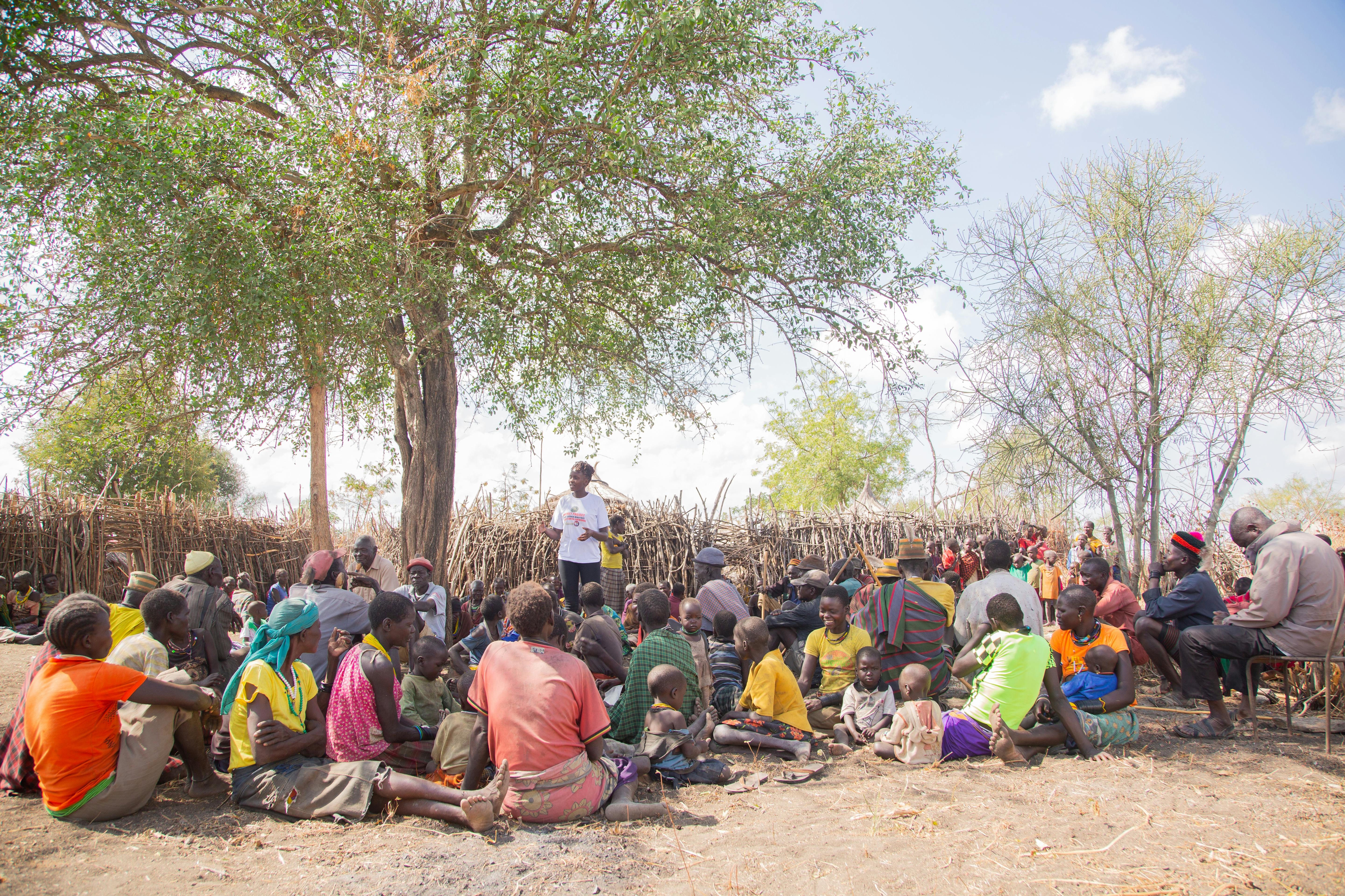 A group of people sitting around a tree · Free Stock Photo