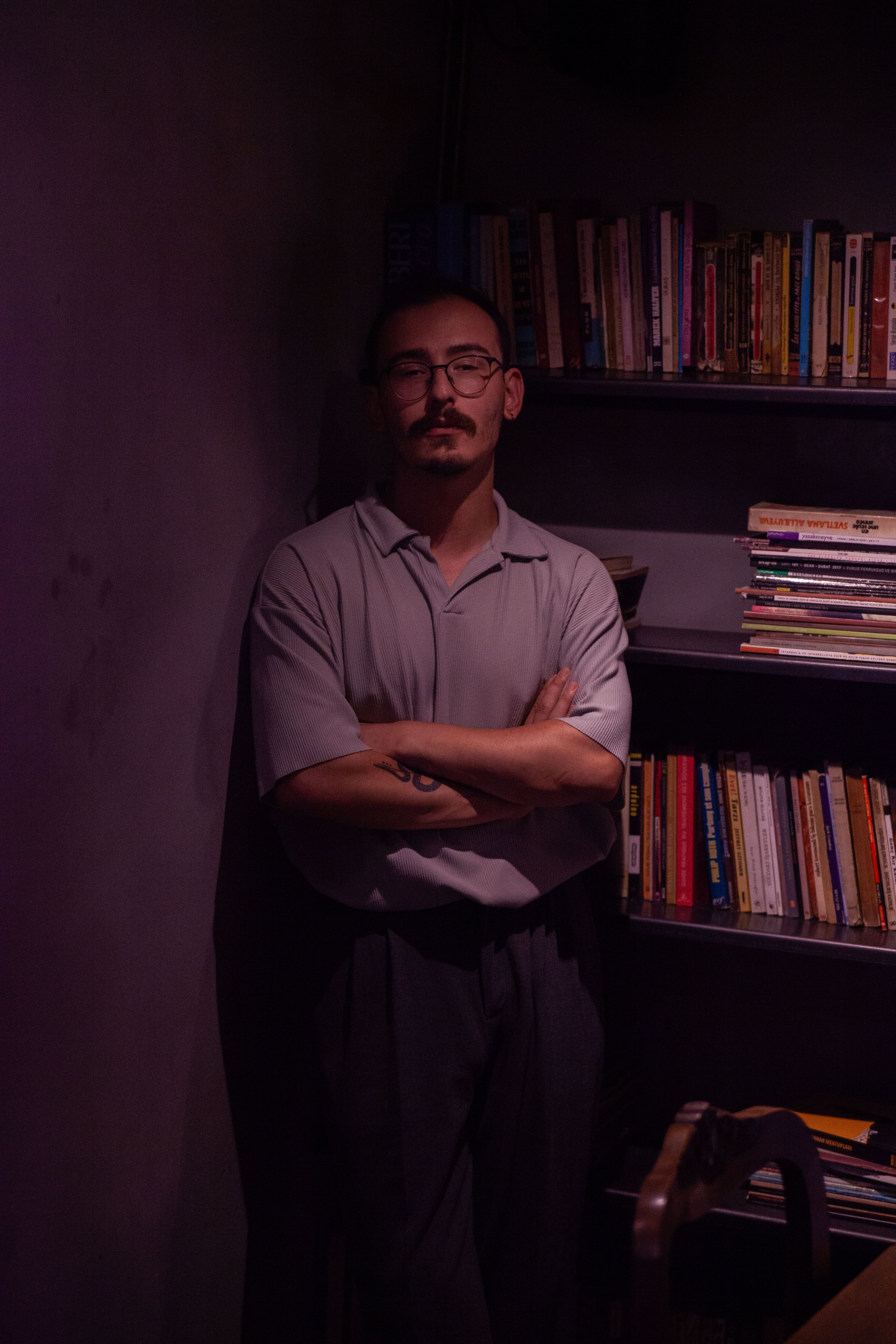A man standing in front of a book shelf · Free Stock Photo