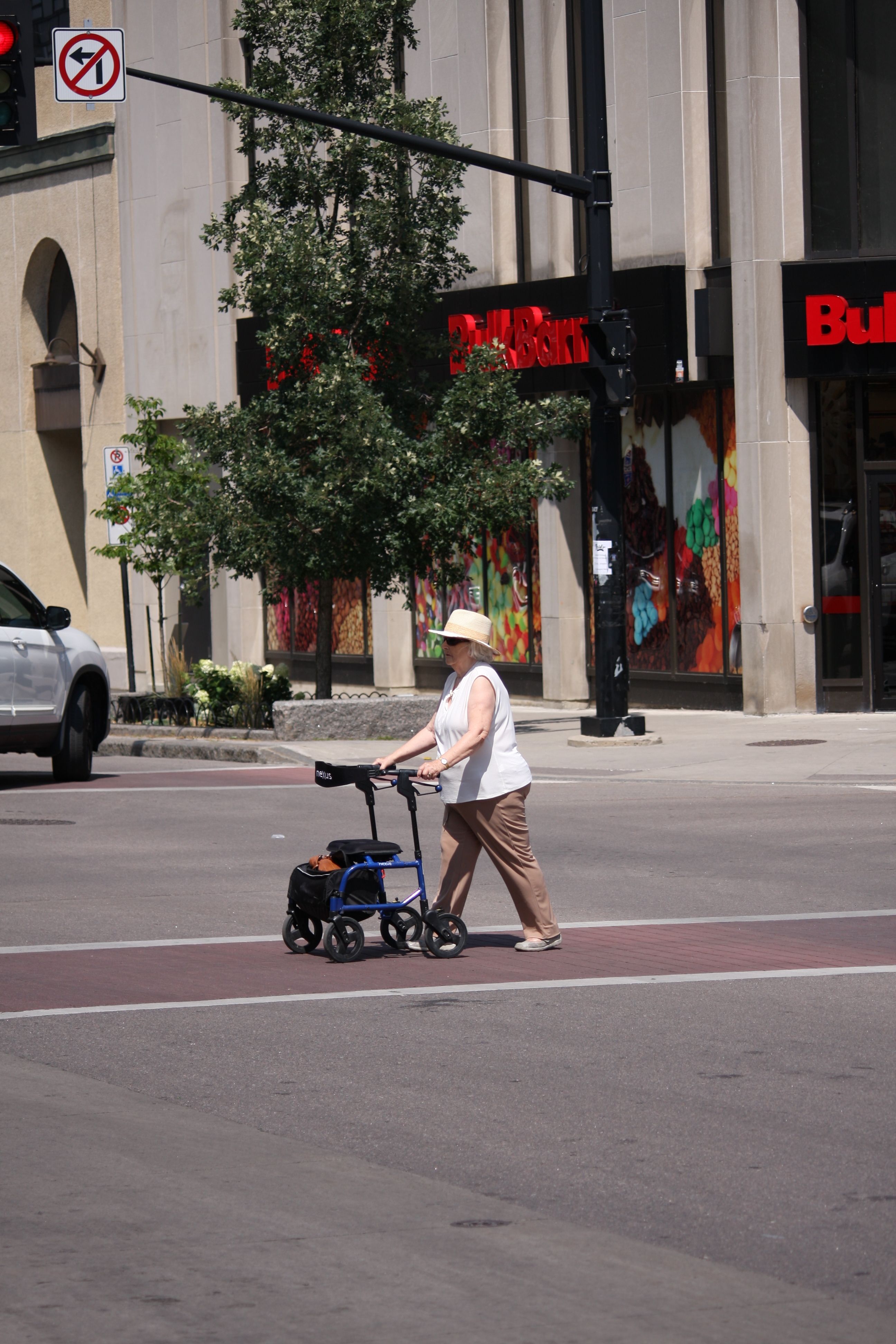 A woman pushing a walker across a street · Free Stock Photo