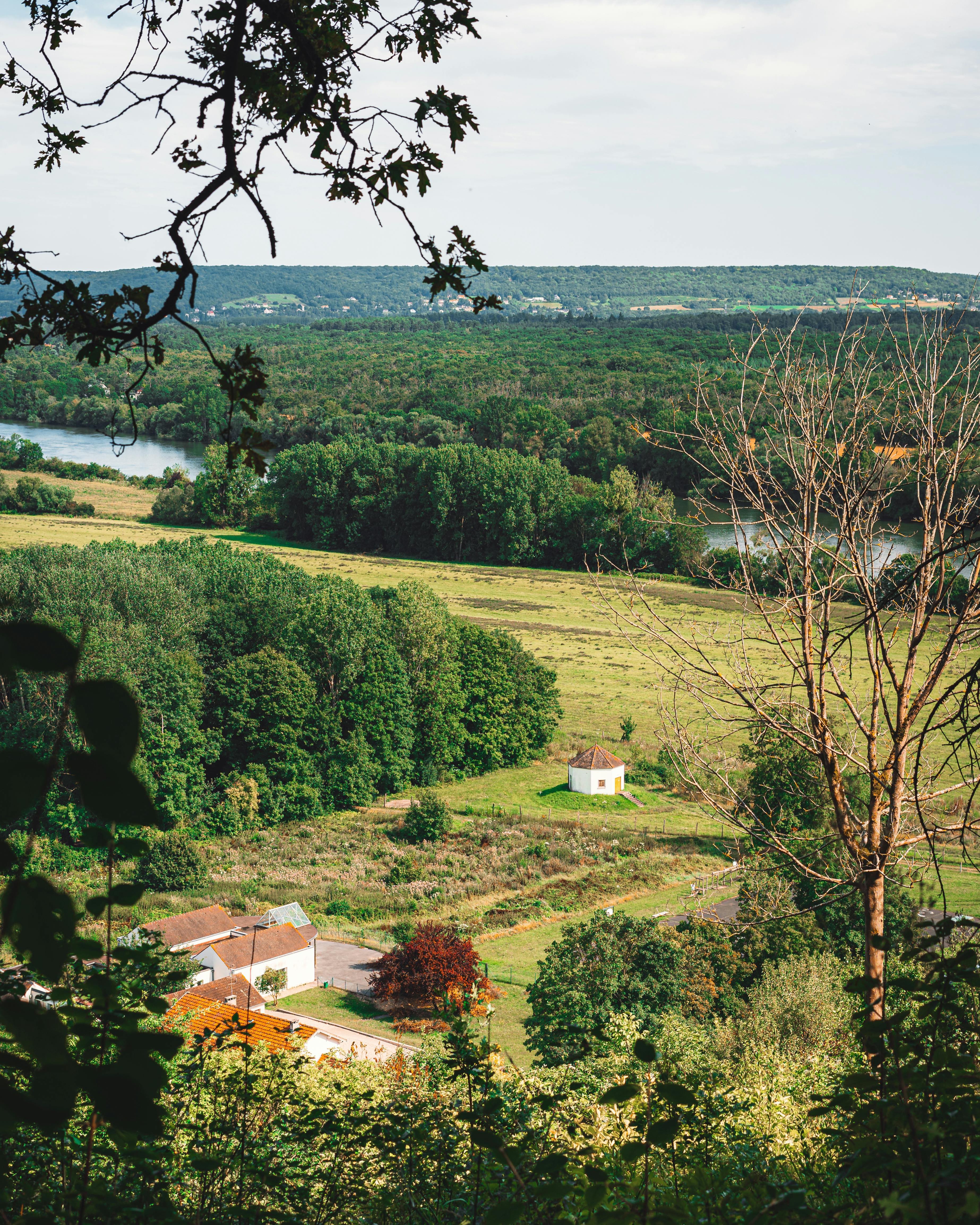 A view of a farm and river from a hill · Free Stock Photo