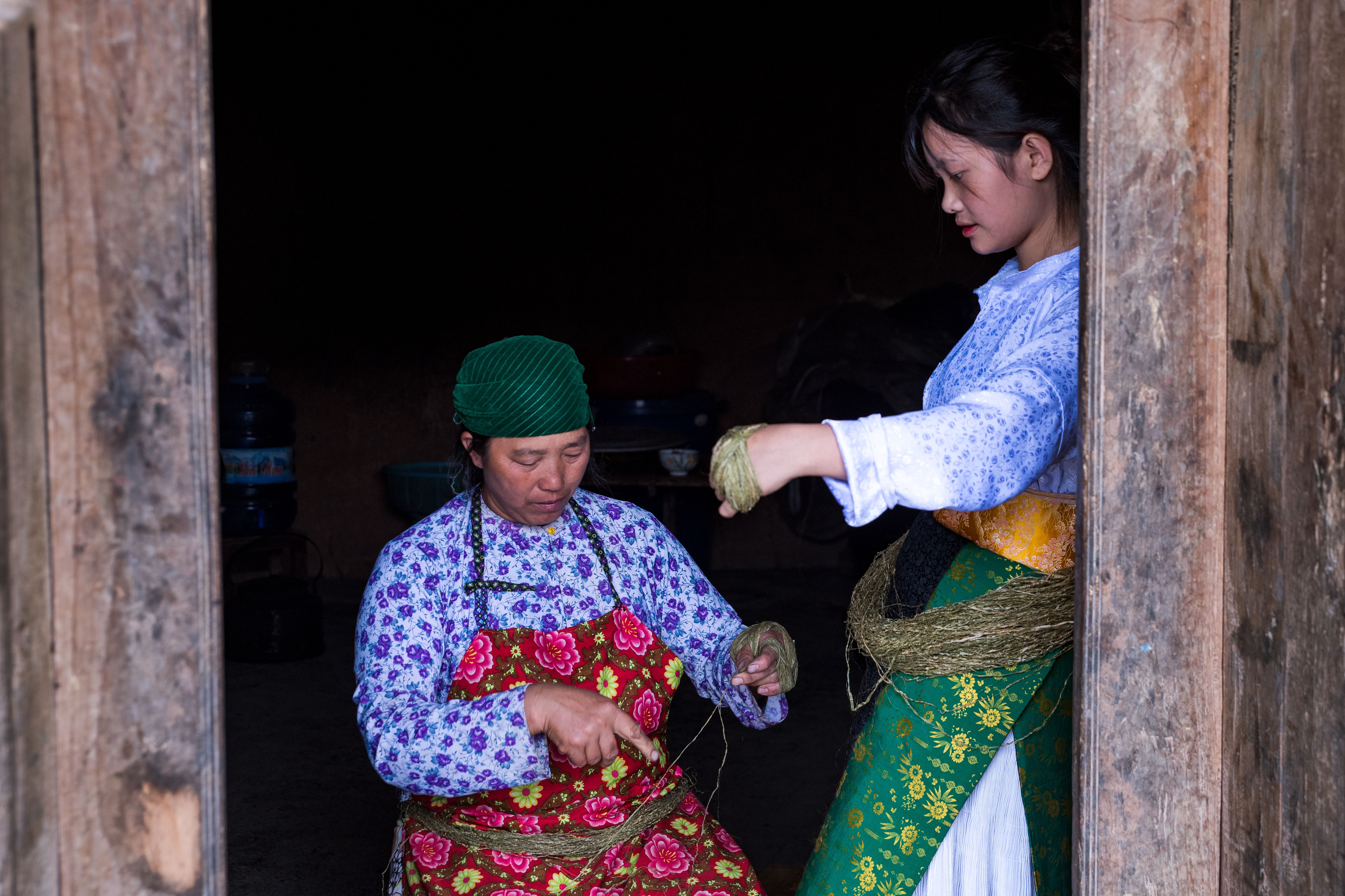 Two women in traditional clothing are working on a craft · Free Stock Photo