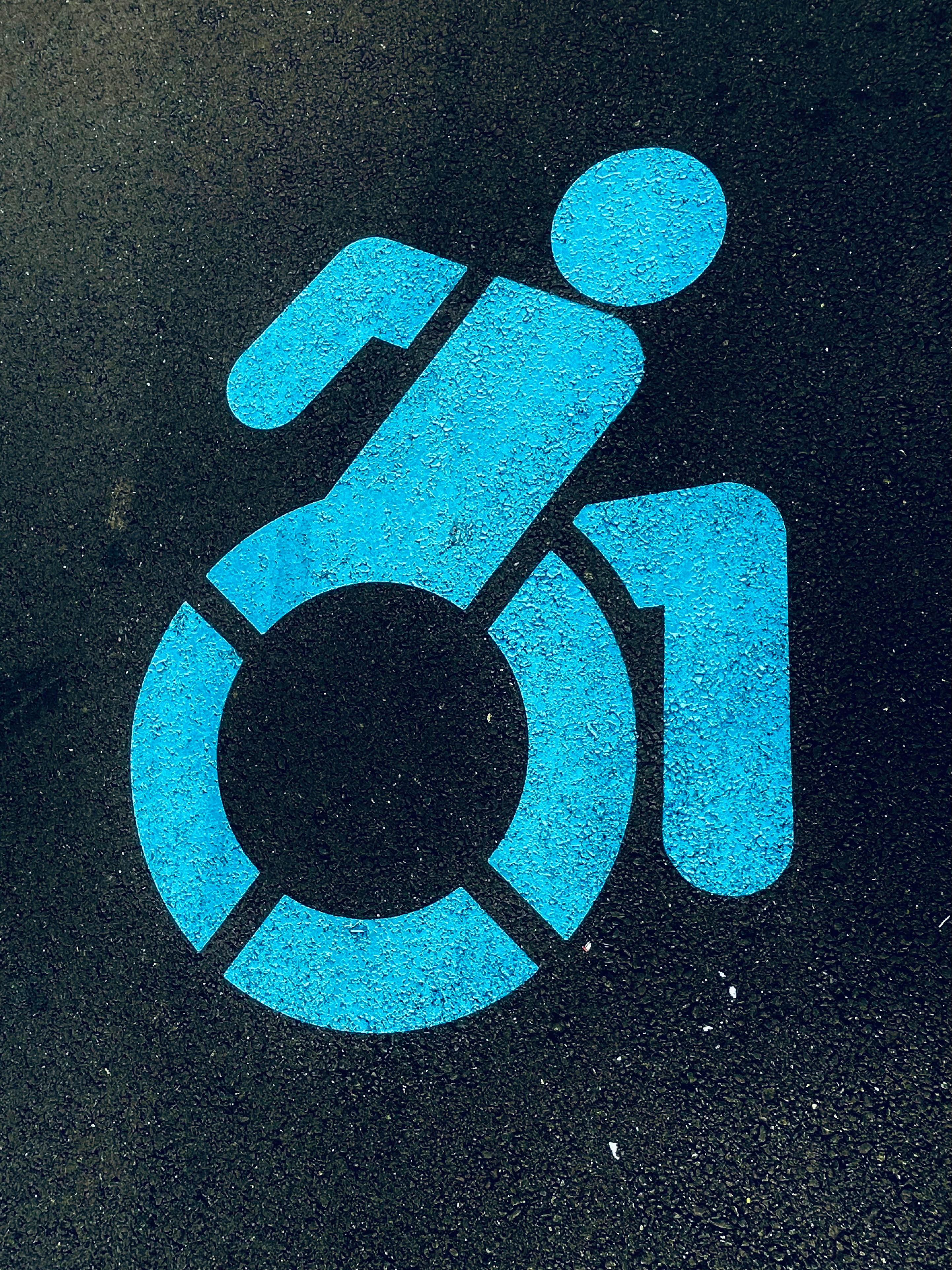 A blue handicapped sign on the ground · Free Stock Photo