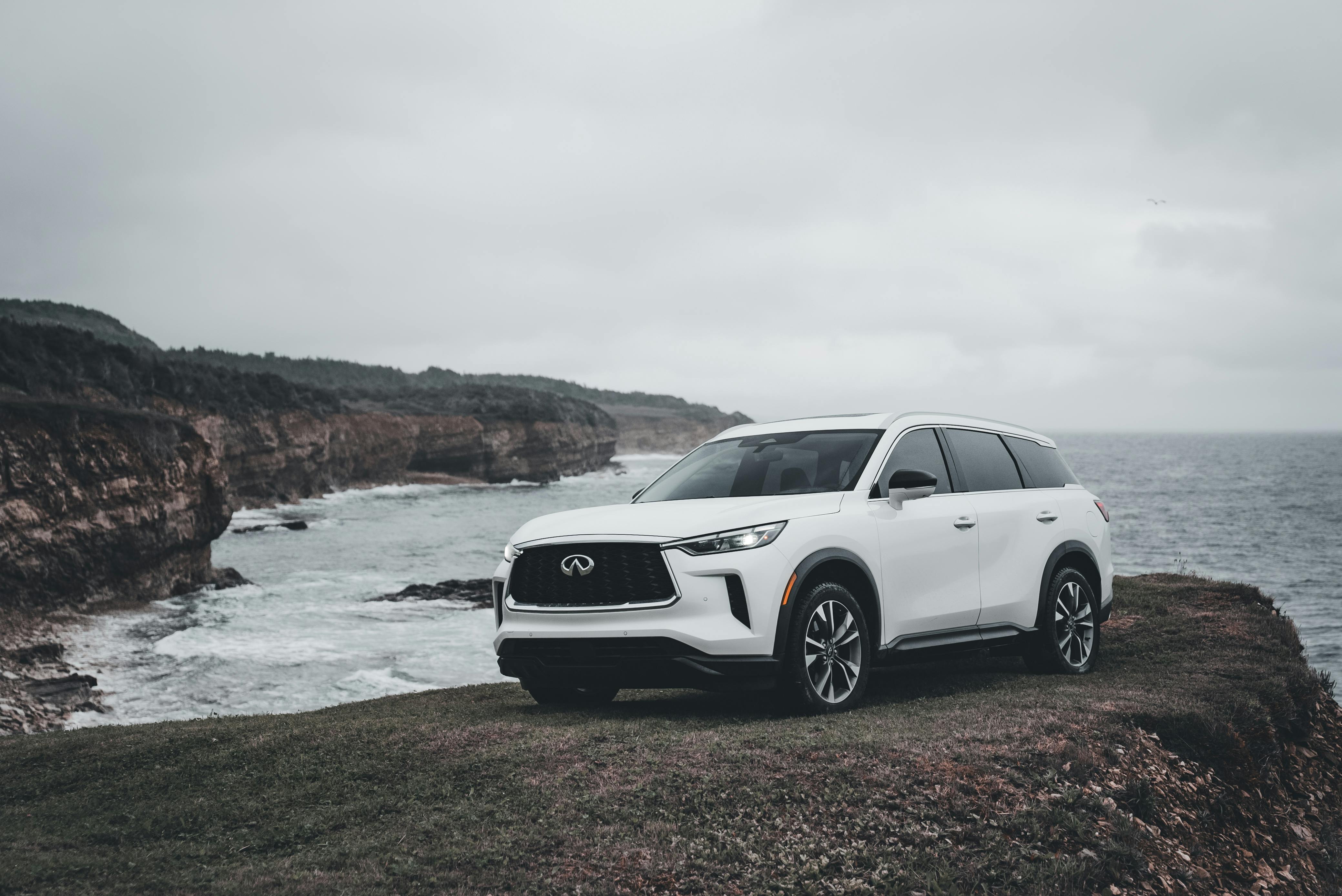 The 2020 infiniti suv parked on the beach near the ocean · Free Stock Photo