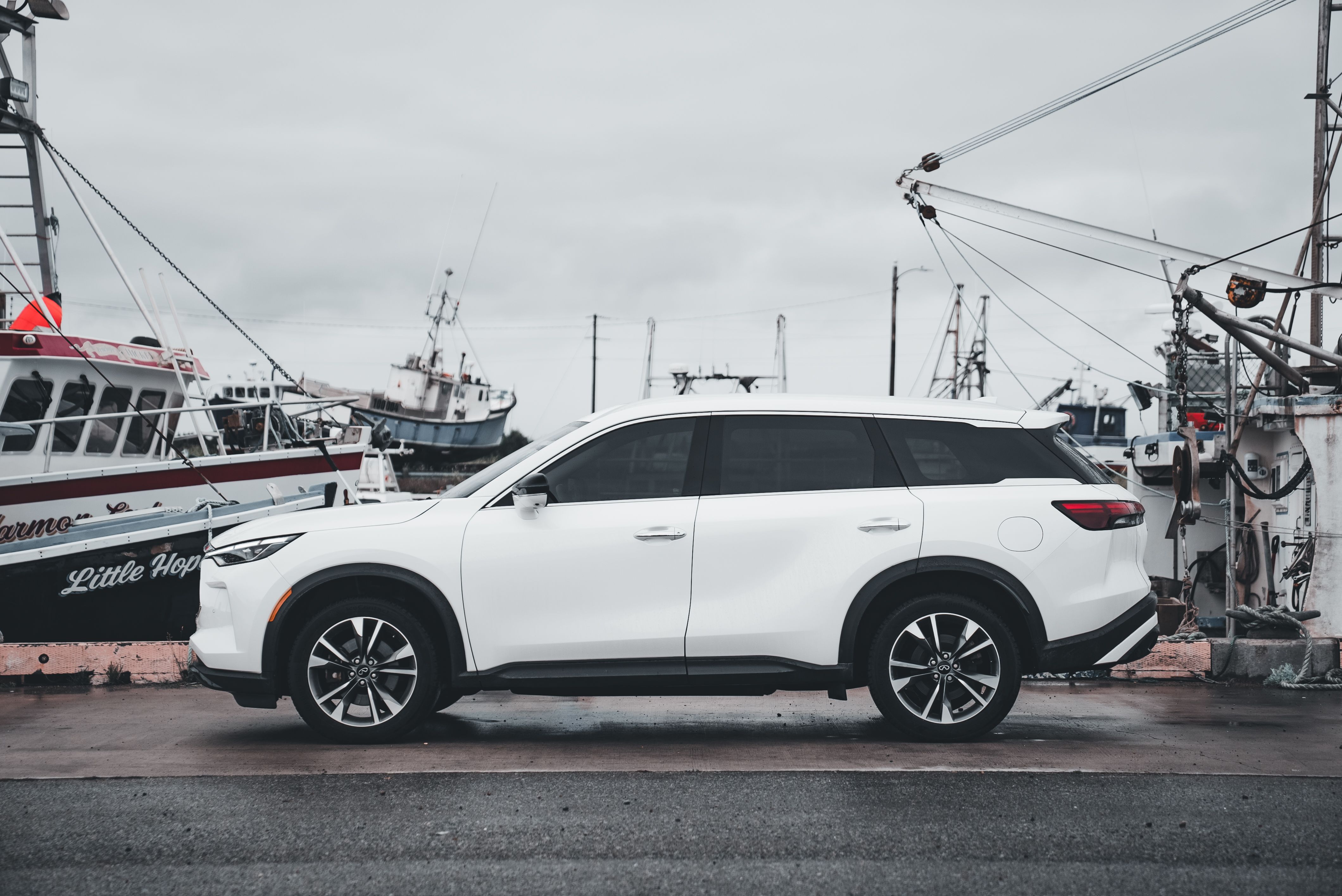 A white suv parked in front of a boat · Free Stock Photo