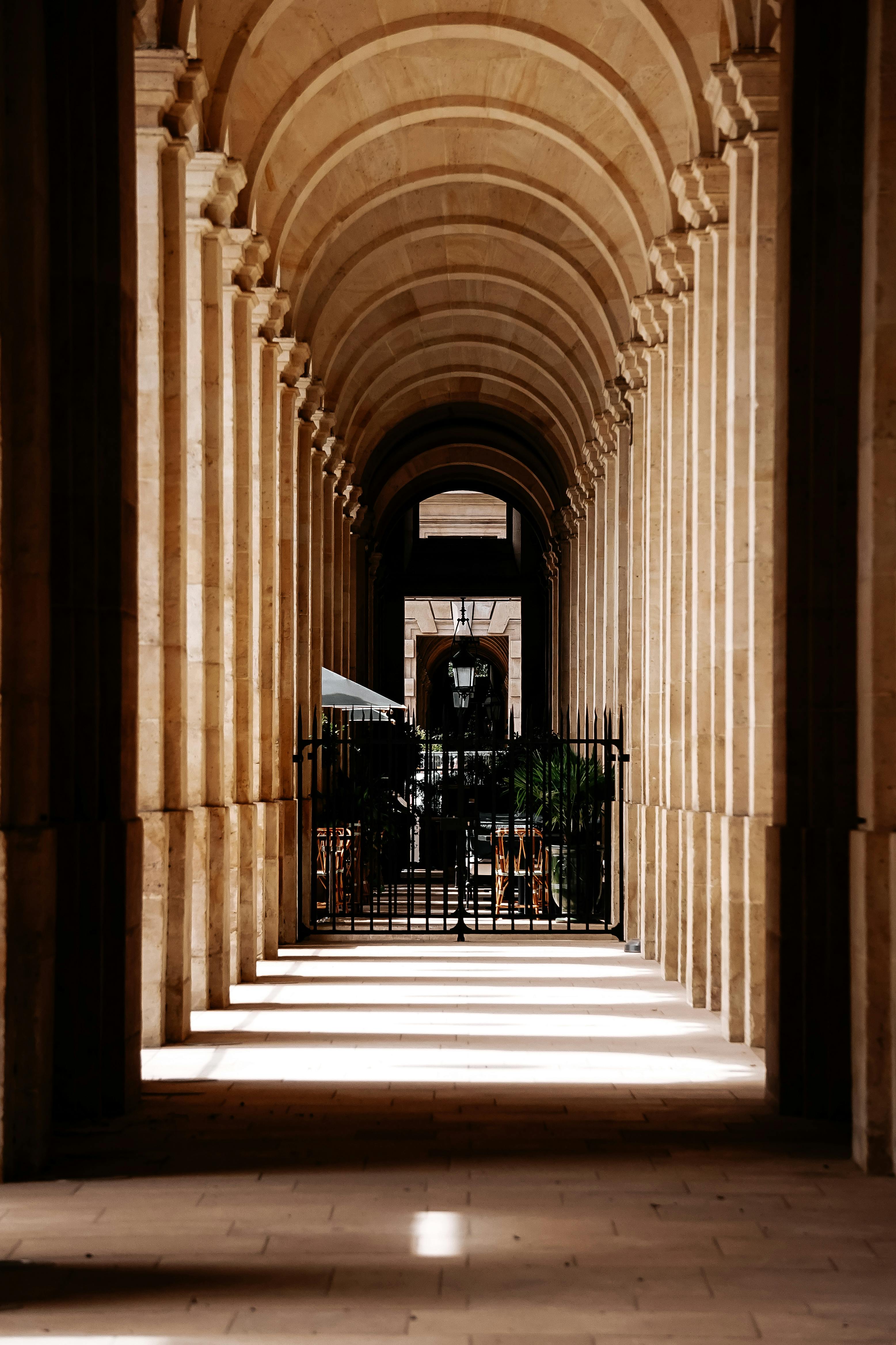 A long corridor with arches and columns · Free Stock Photo