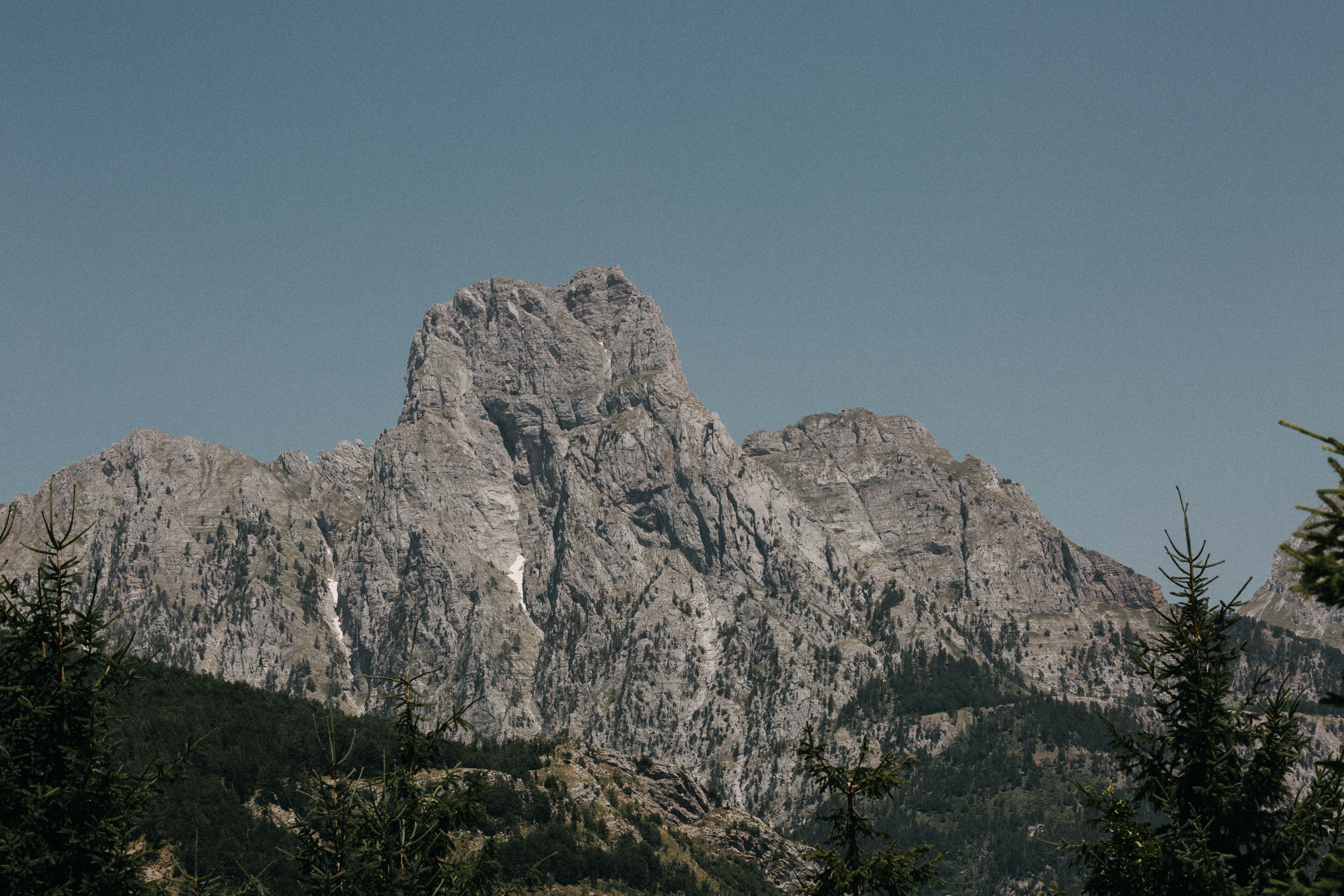 A mountain with a large rock formation in the background · Free Stock Photo