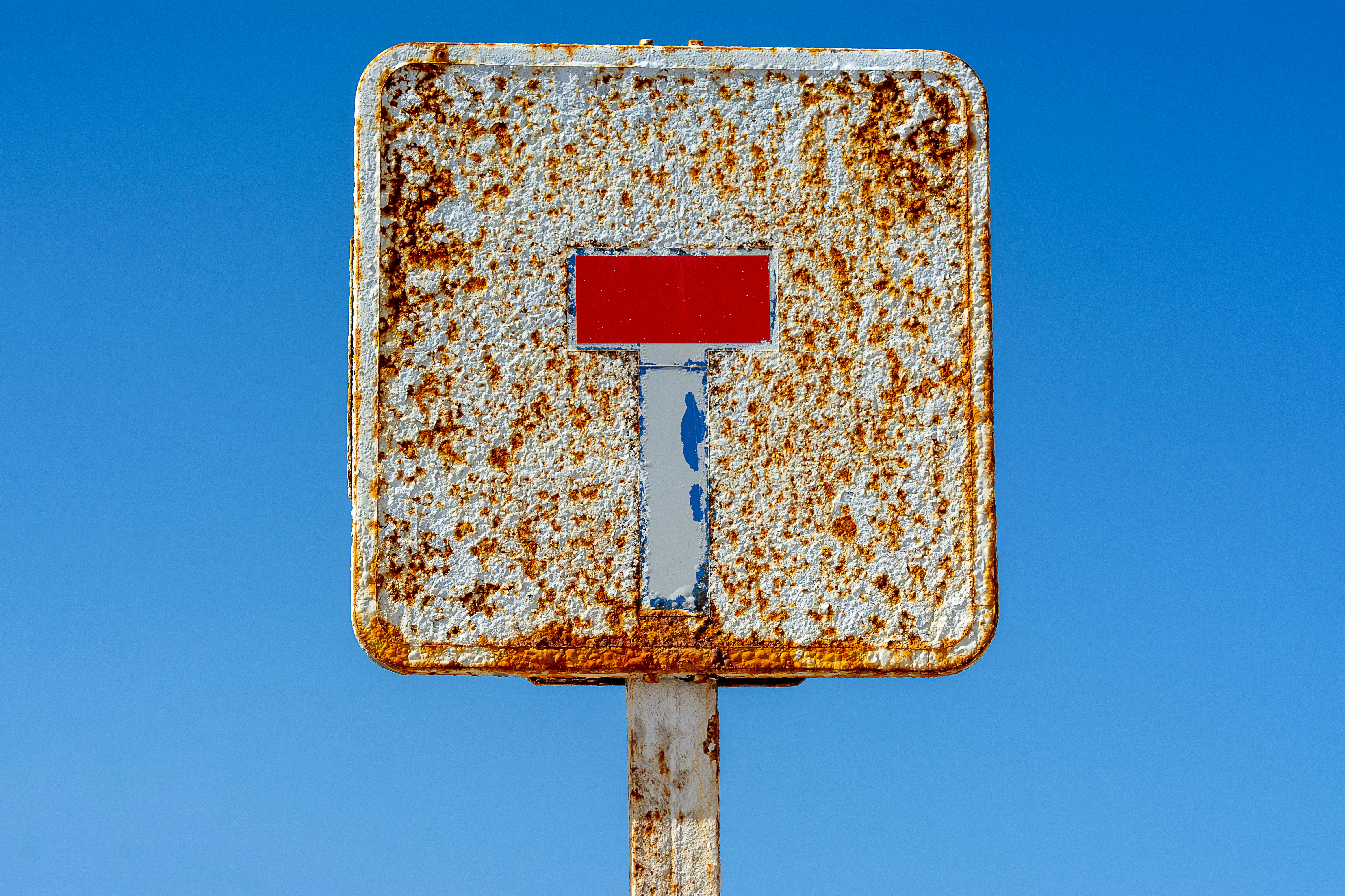 A rusty sign with a red stop sign on it · Free Stock Photo