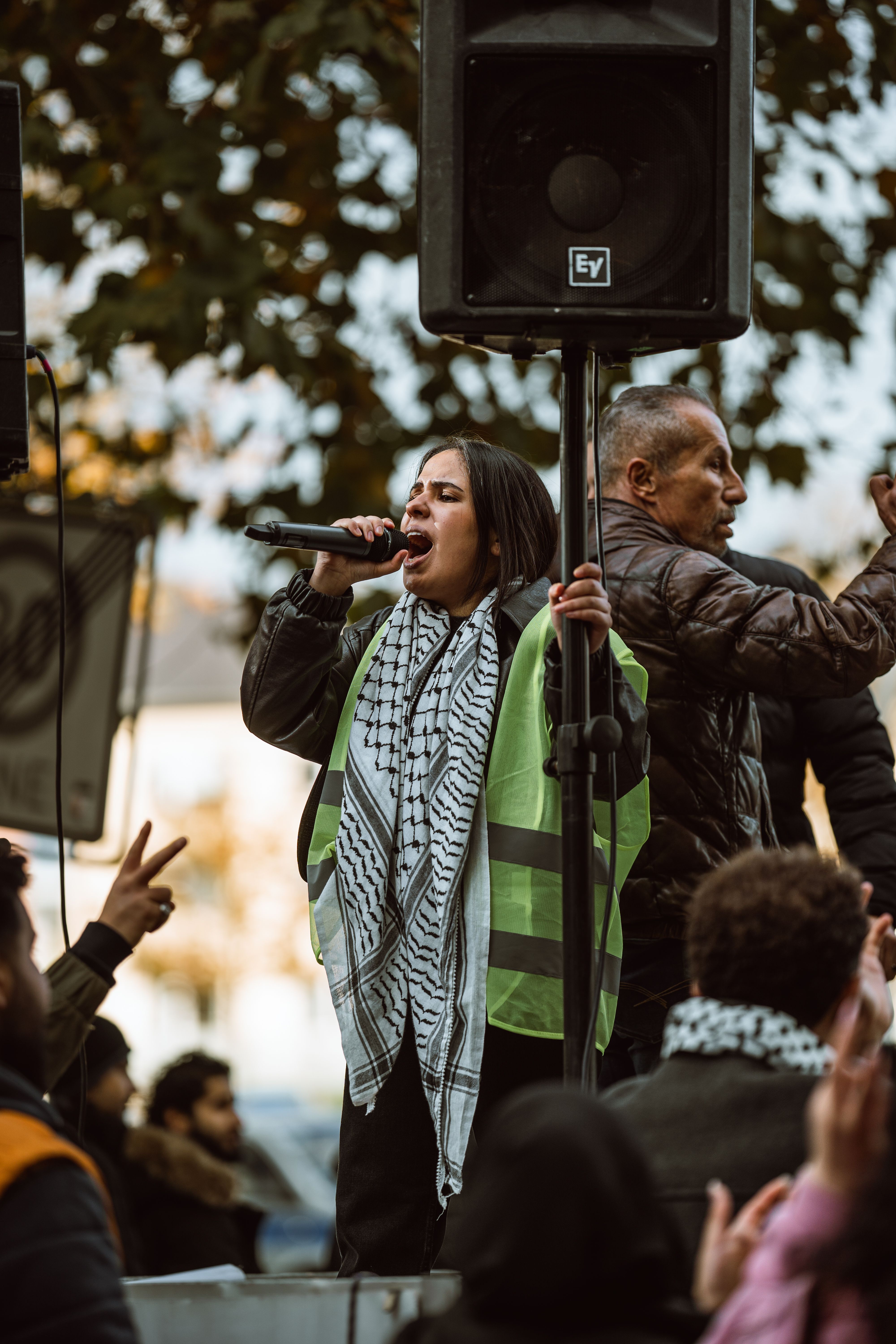 A woman singing into a microphone at a protest · Free Stock Photo