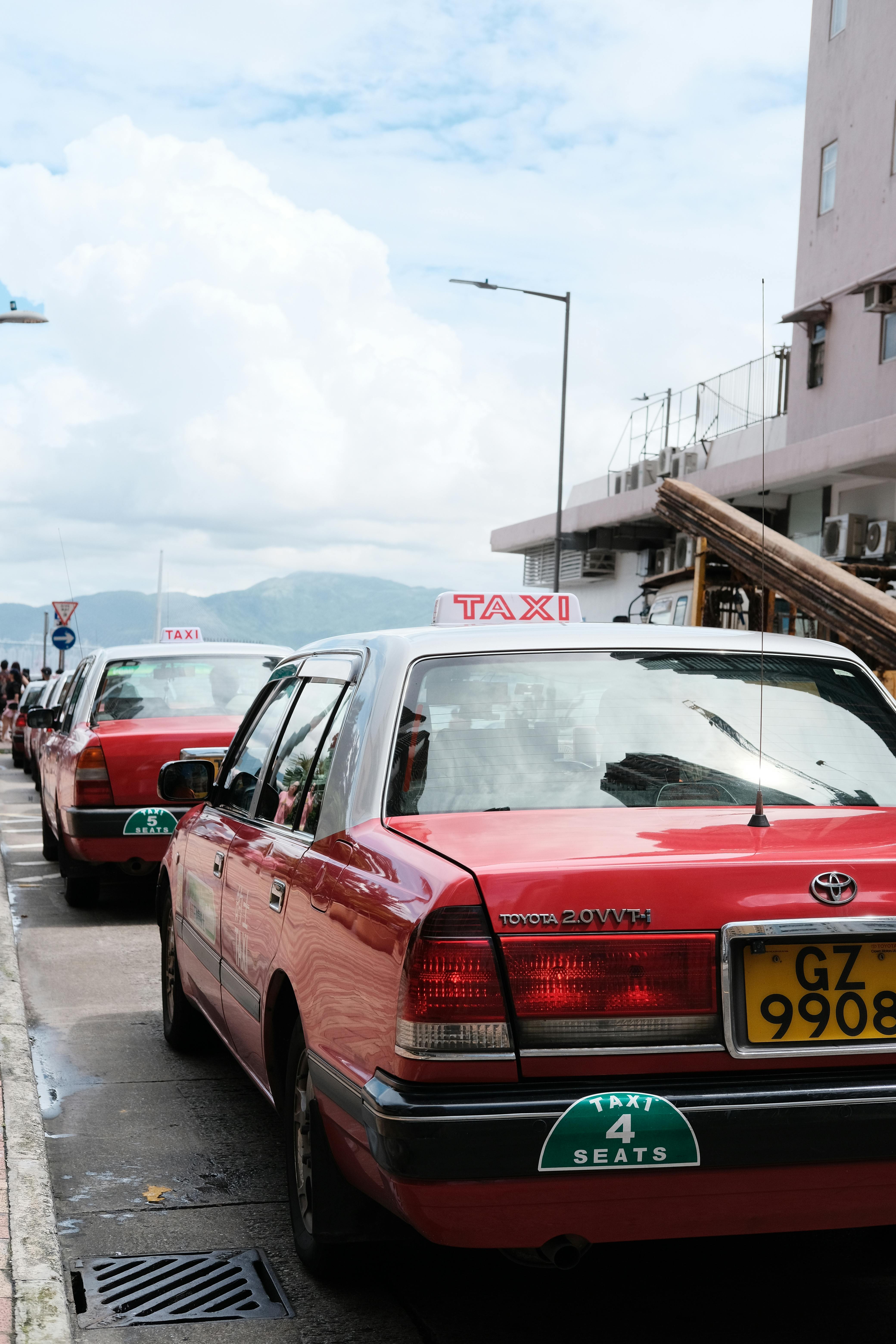 A red taxi parked on the side of the road · Free Stock Photo