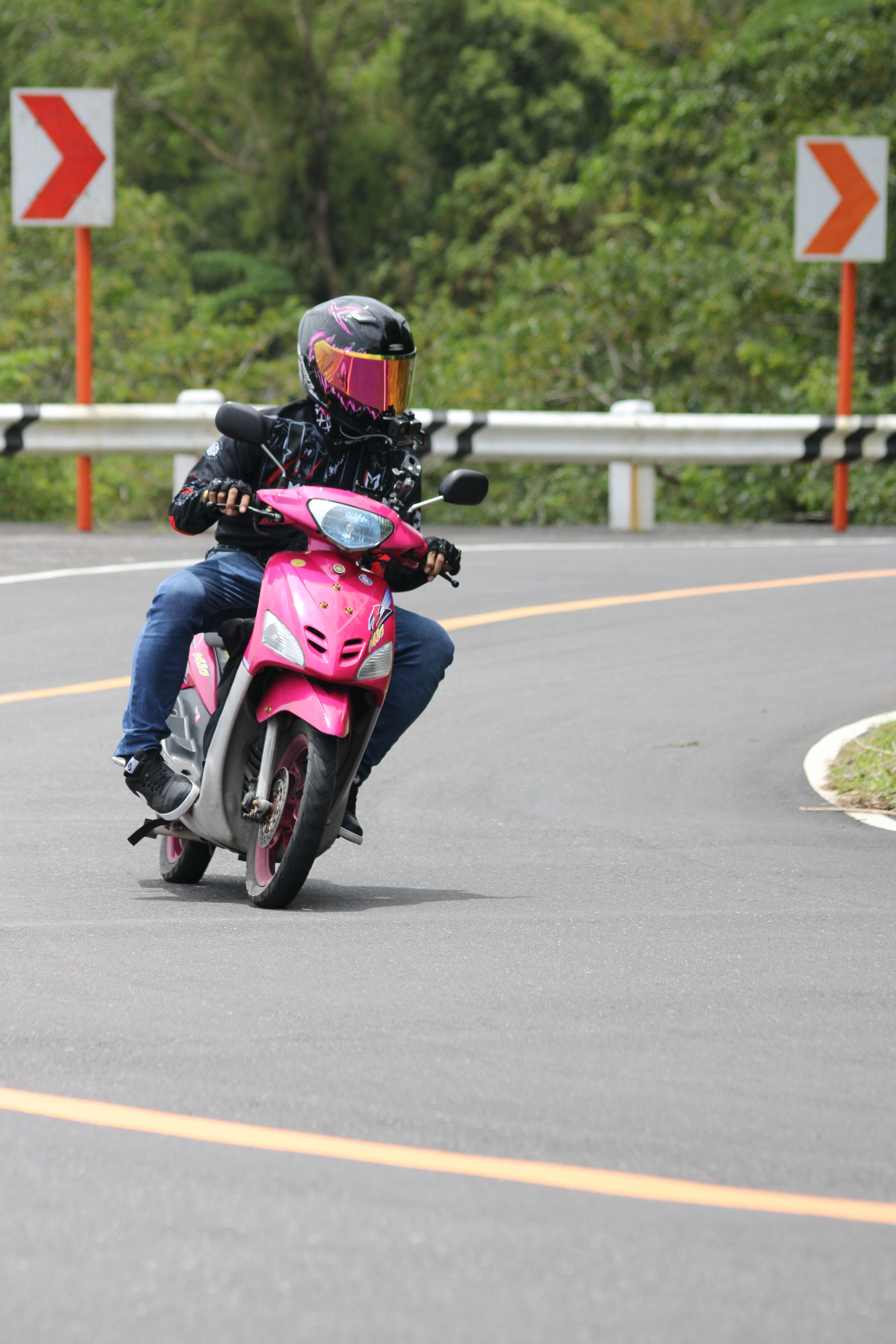 A person on a pink motorcycle riding down a road · Free Stock Photo