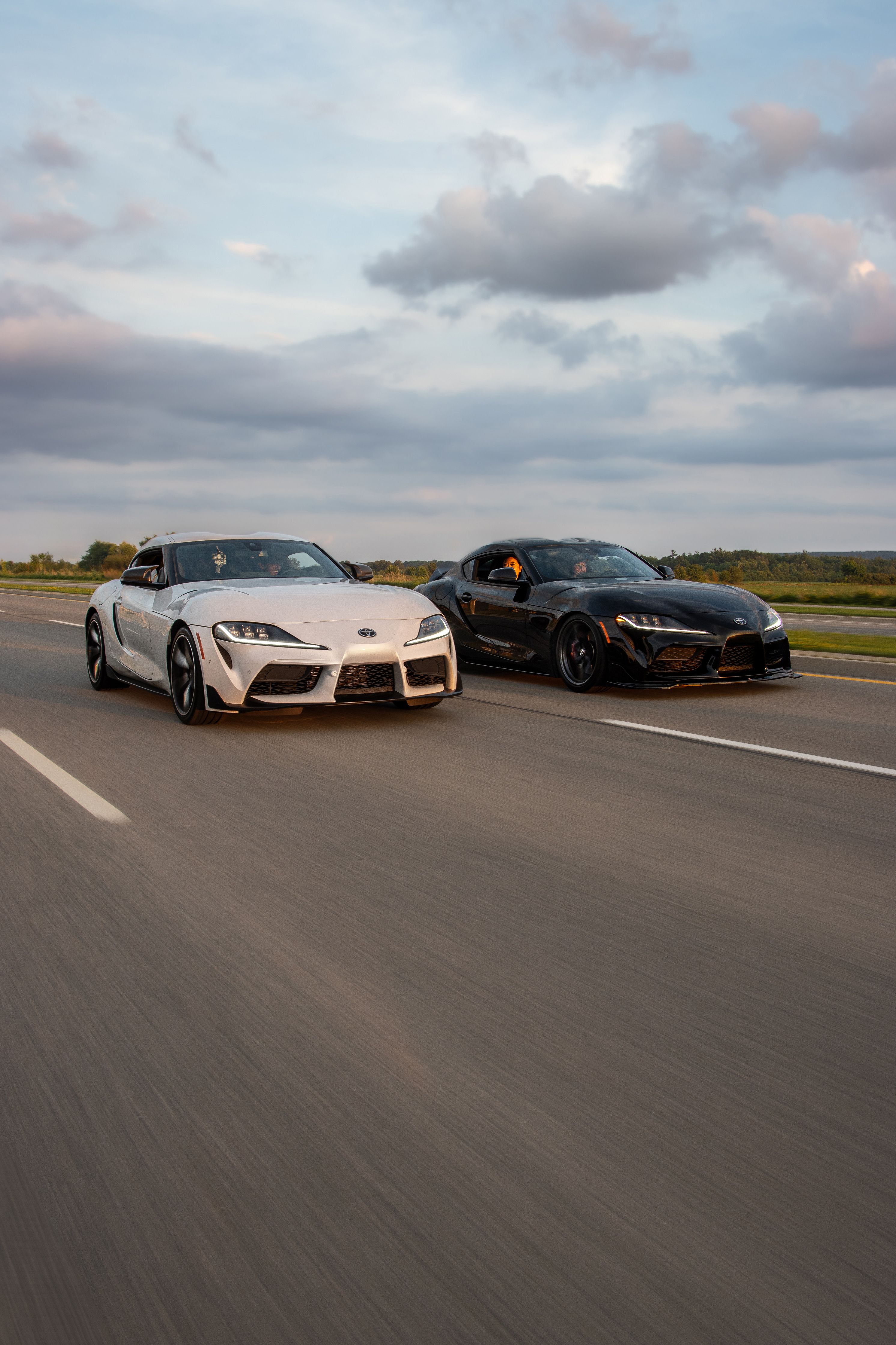 Two sports cars driving down a highway · Free Stock Photo