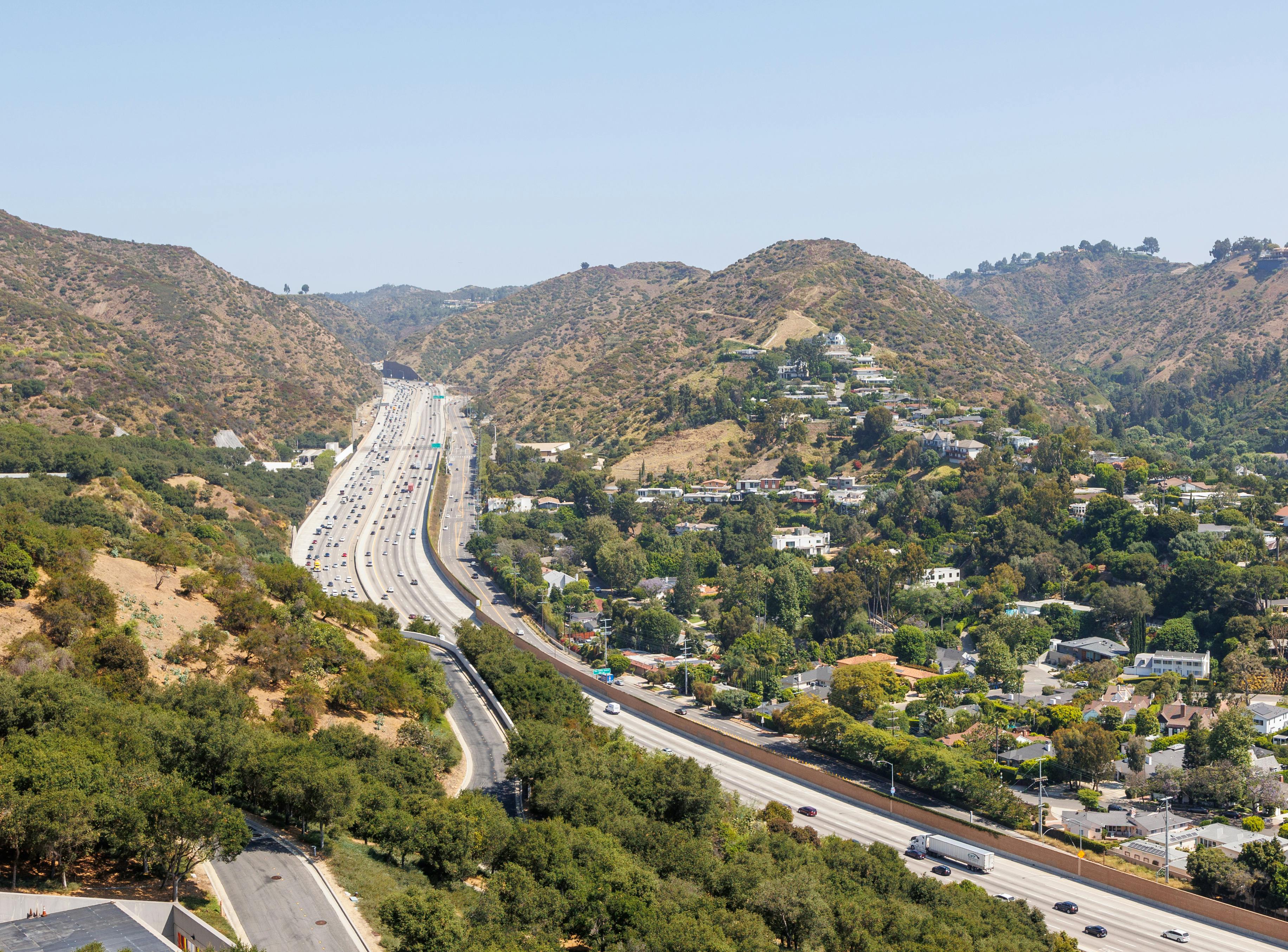 The view from the top of a hill overlooking a freeway · Free Stock Photo