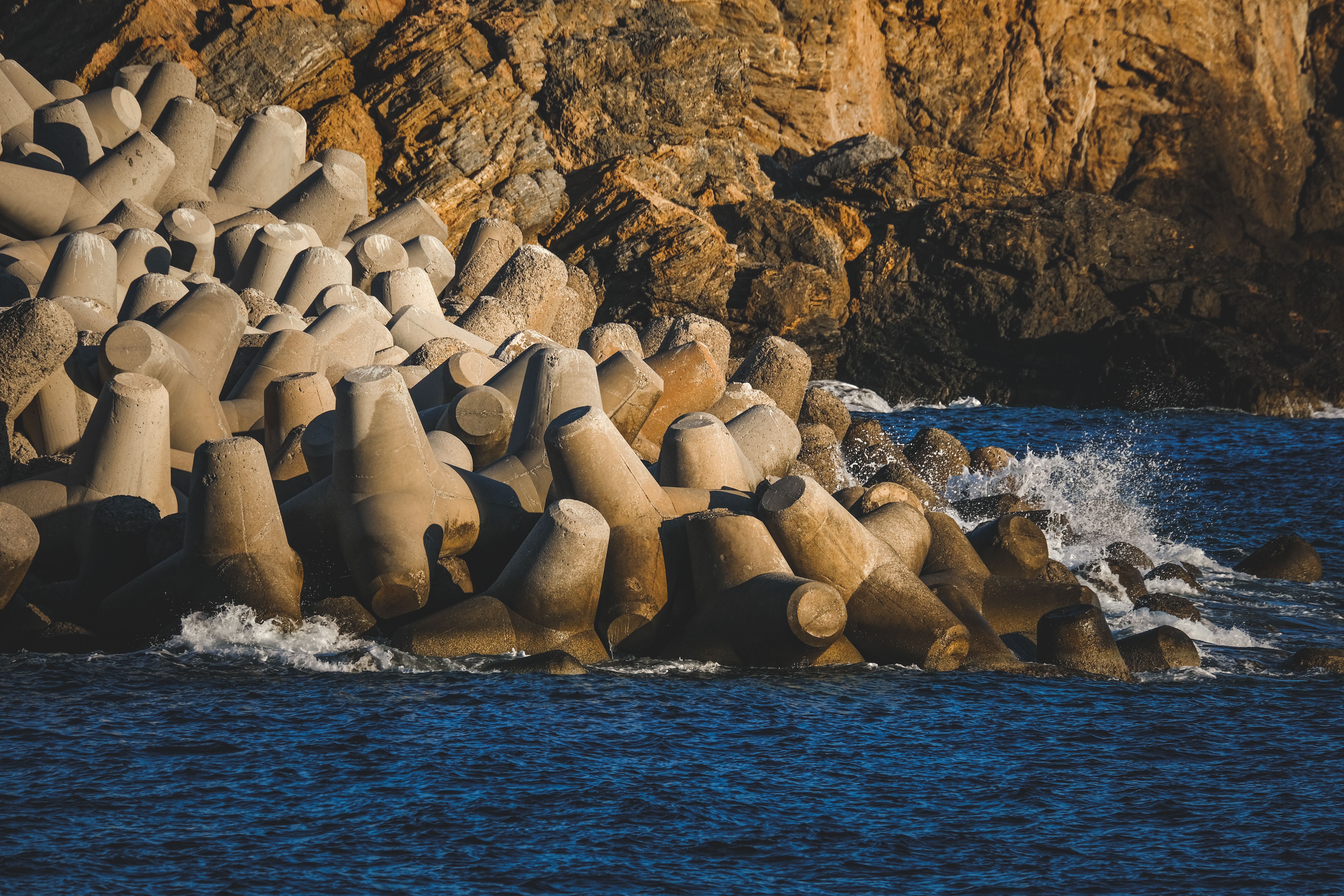 A large pile of rocks on the ocean shore · Free Stock Photo