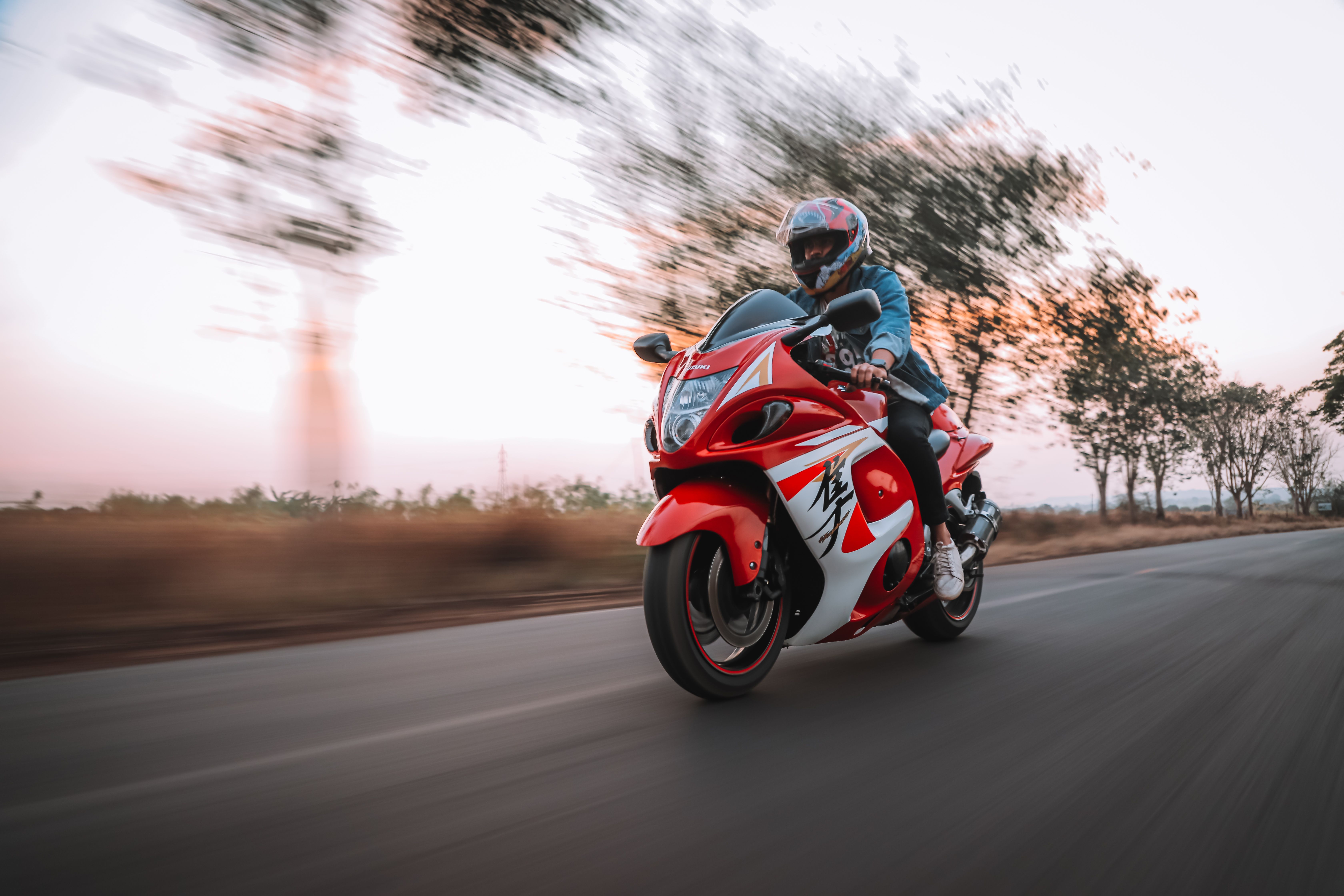 A person riding a red motorcycle on a road · Free Stock Photo
