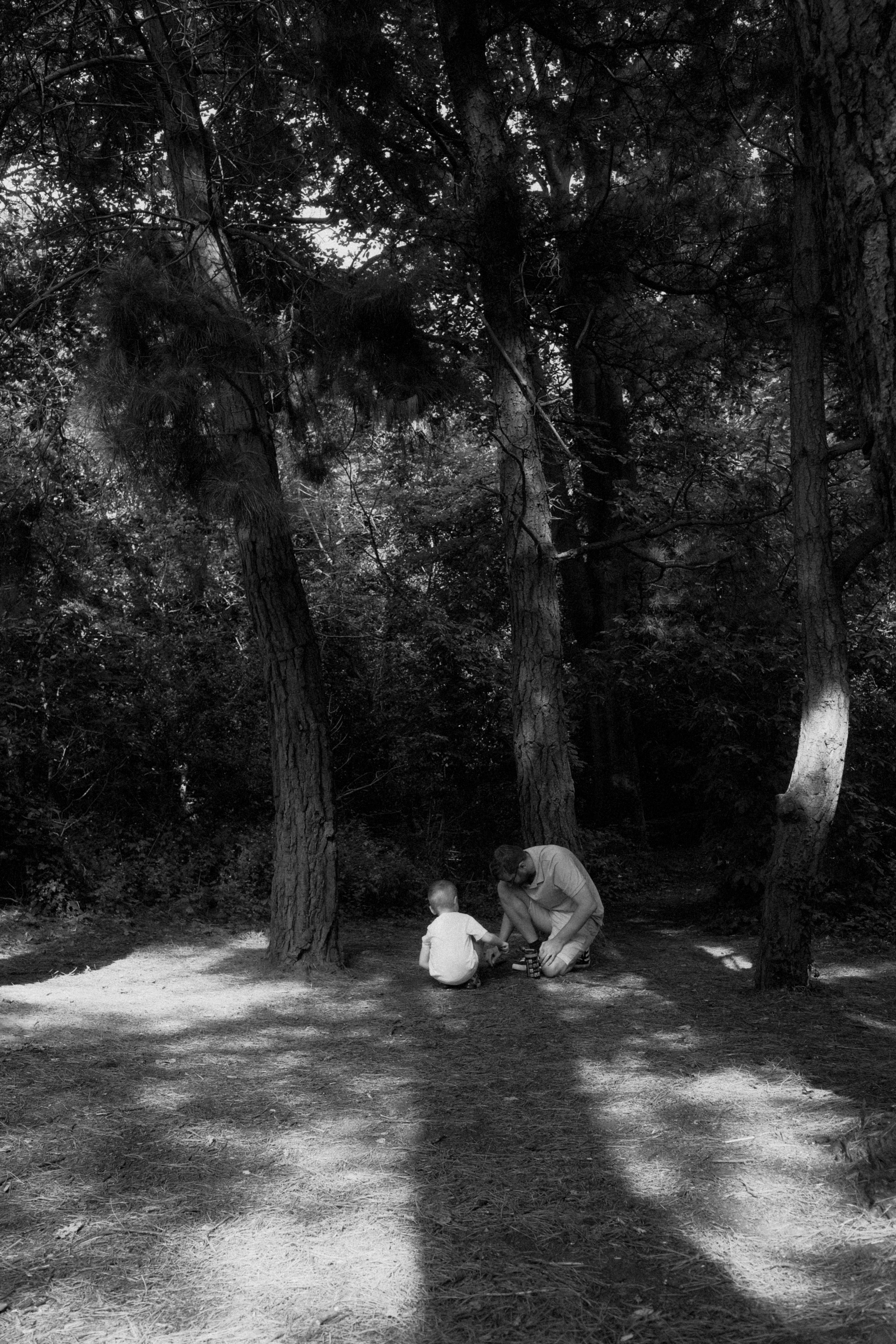 A black and white photo of two people sitting in the shade · Free Stock ...