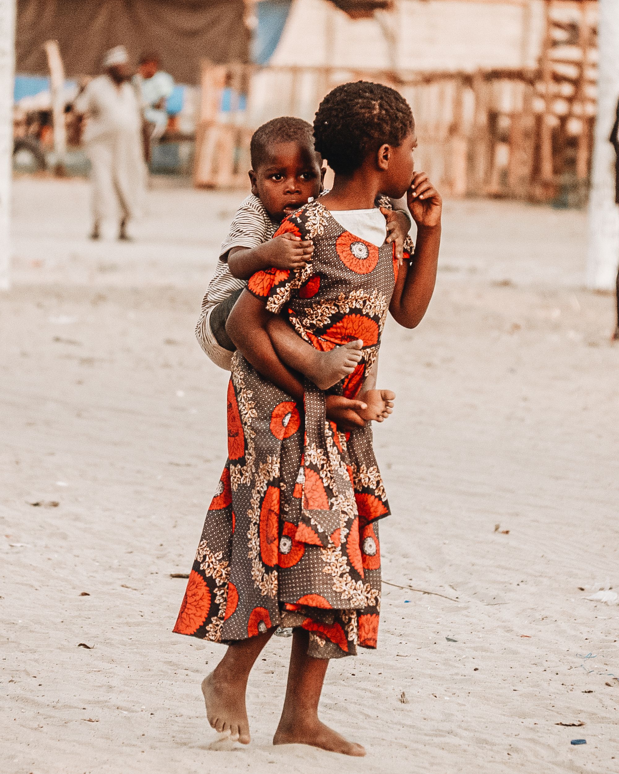 A young girl carrying a child on her back · Free Stock Photo