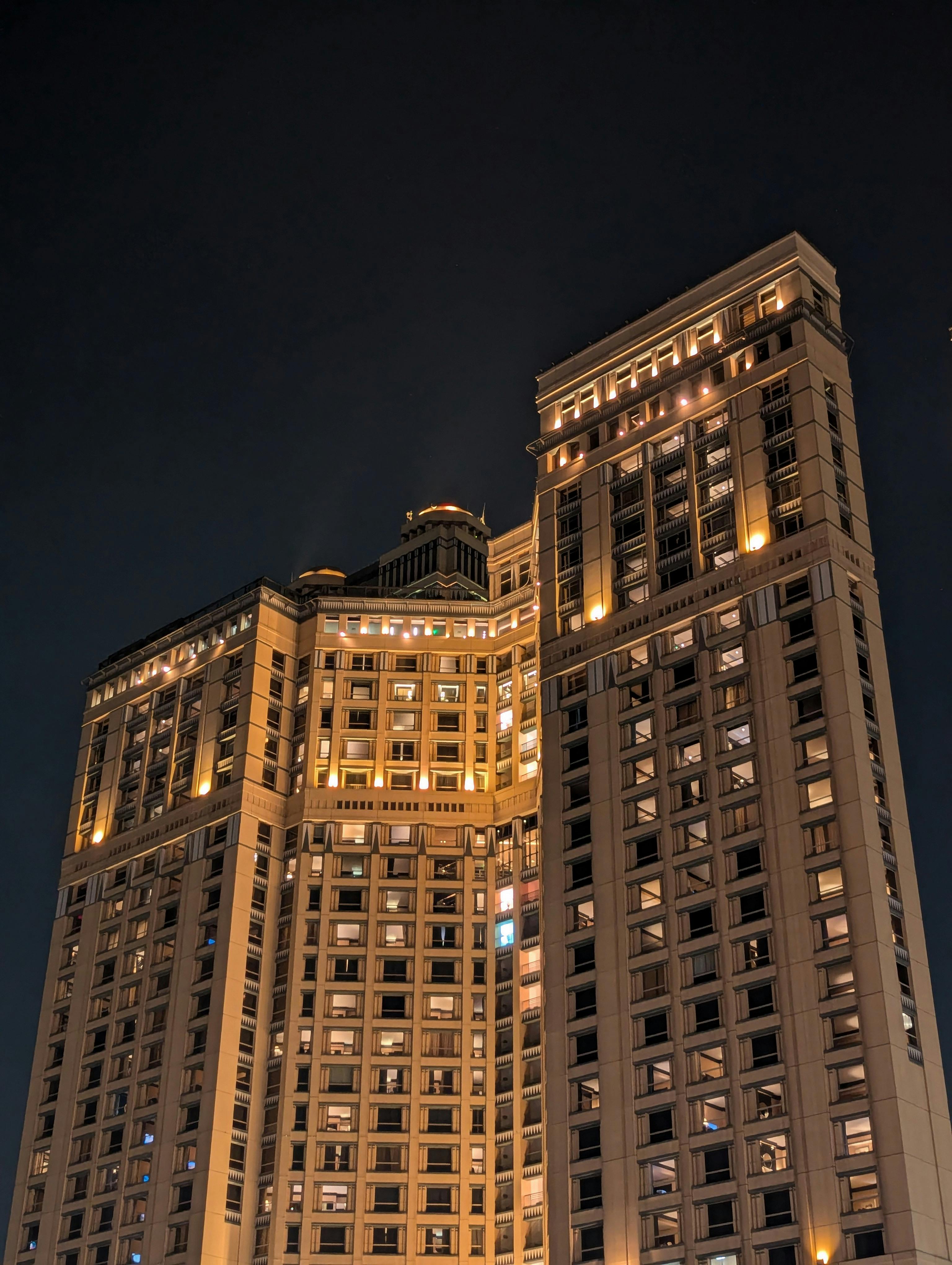 The tall building is lit up at night · Free Stock Photo
