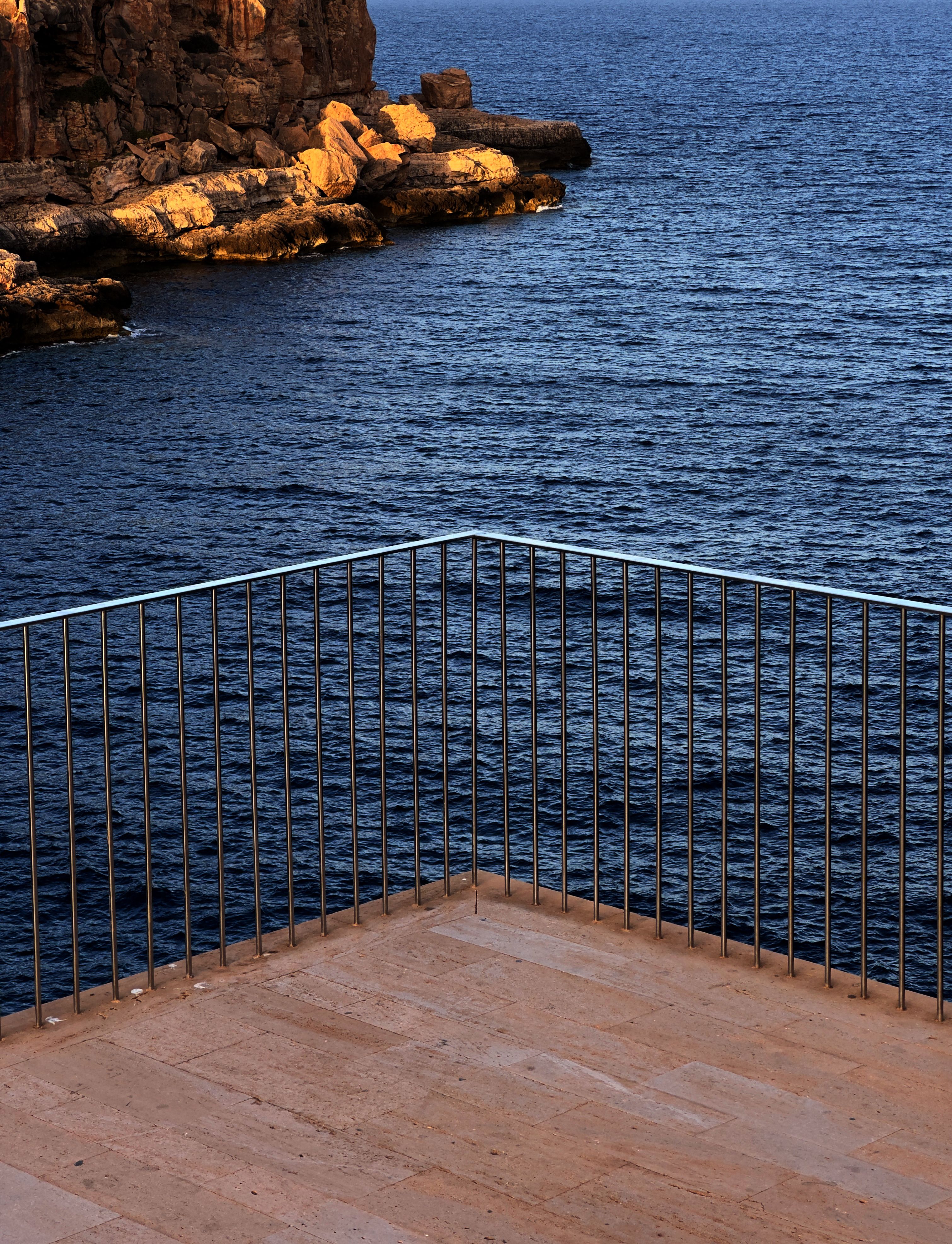 A balcony overlooking the ocean with a railing · Free Stock Photo